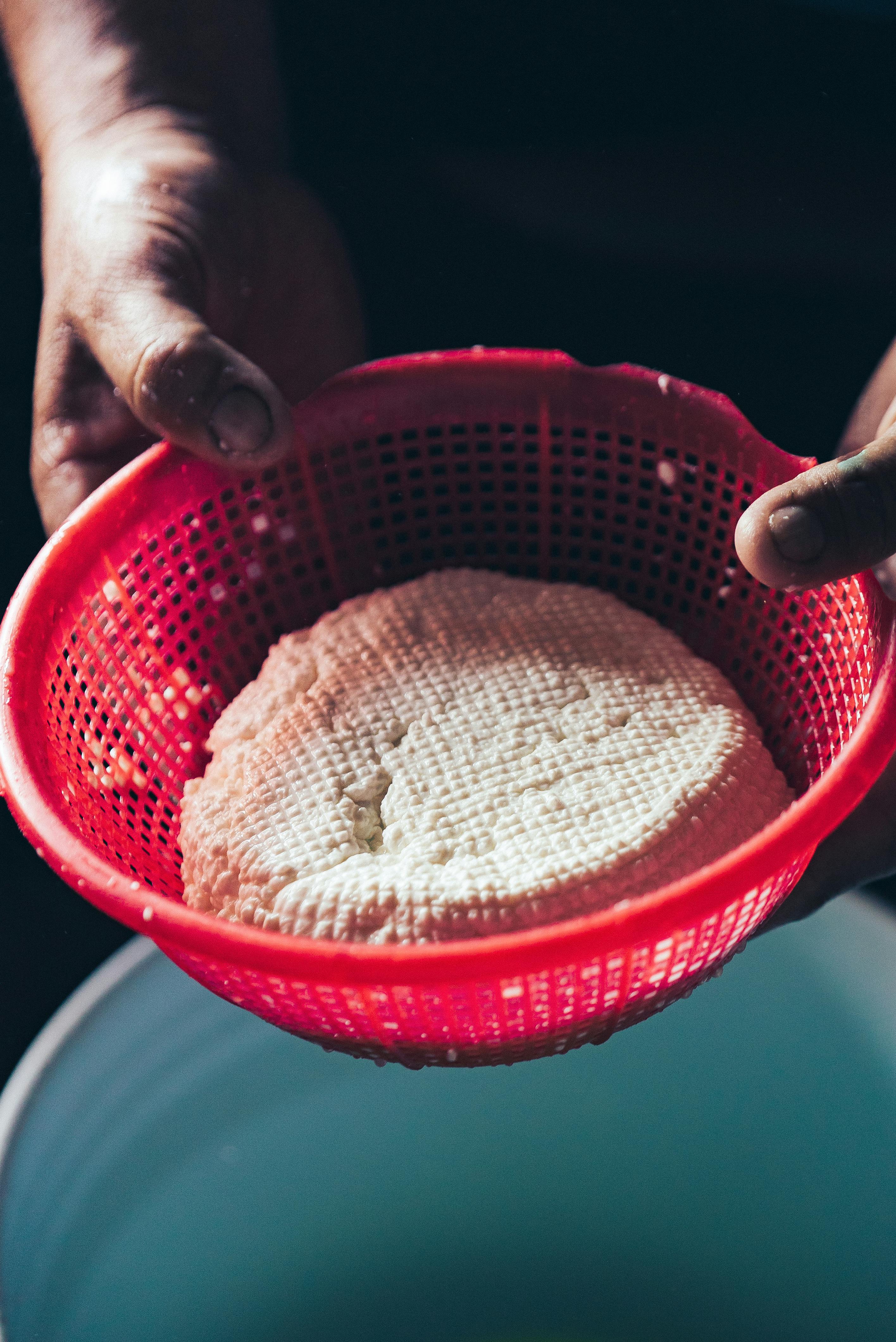 Person with sieve of homemade cheese · Free Stock Photo