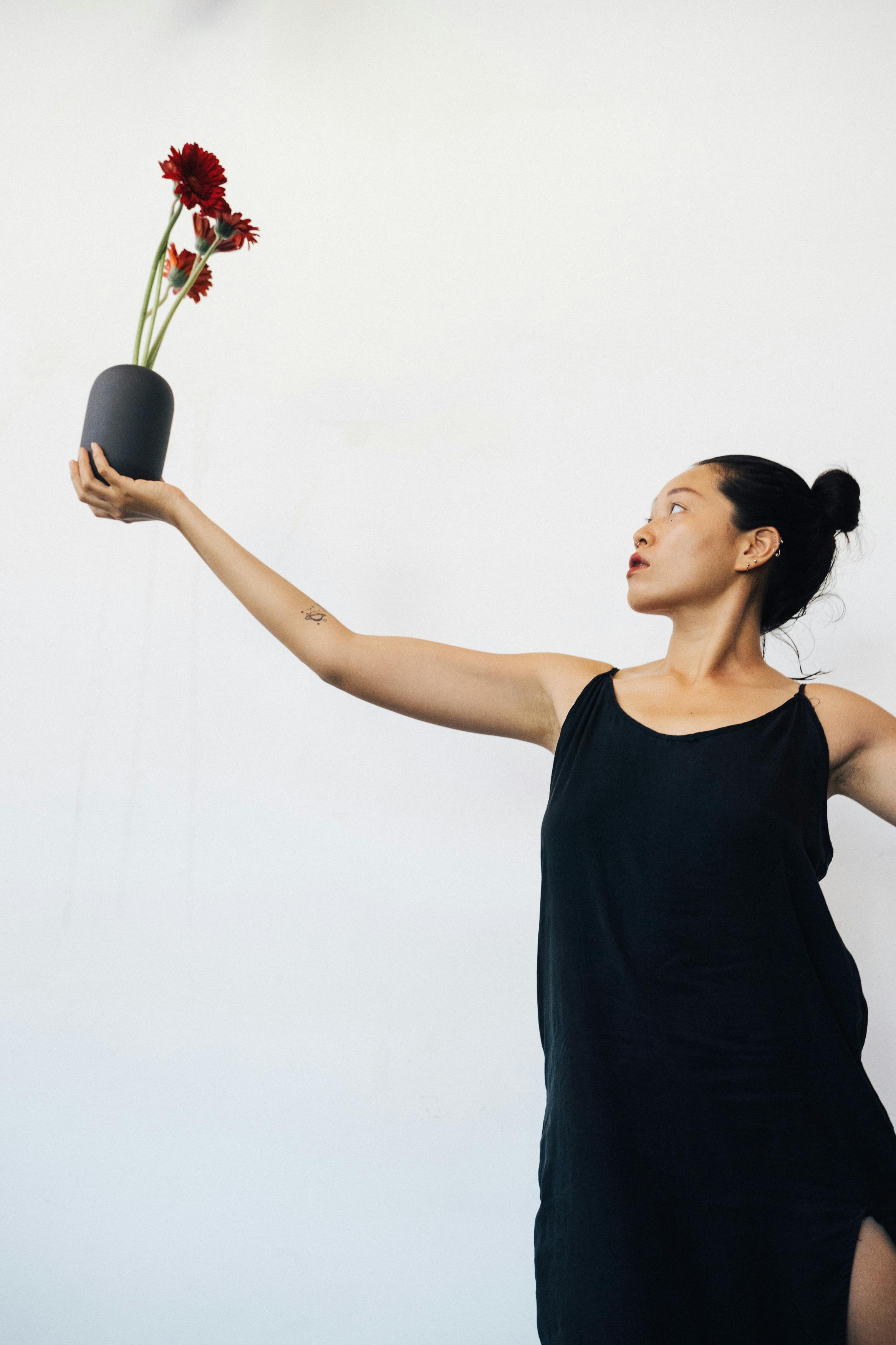 Woman in Black Dress Smelling a Red Flower · Free Stock Photo