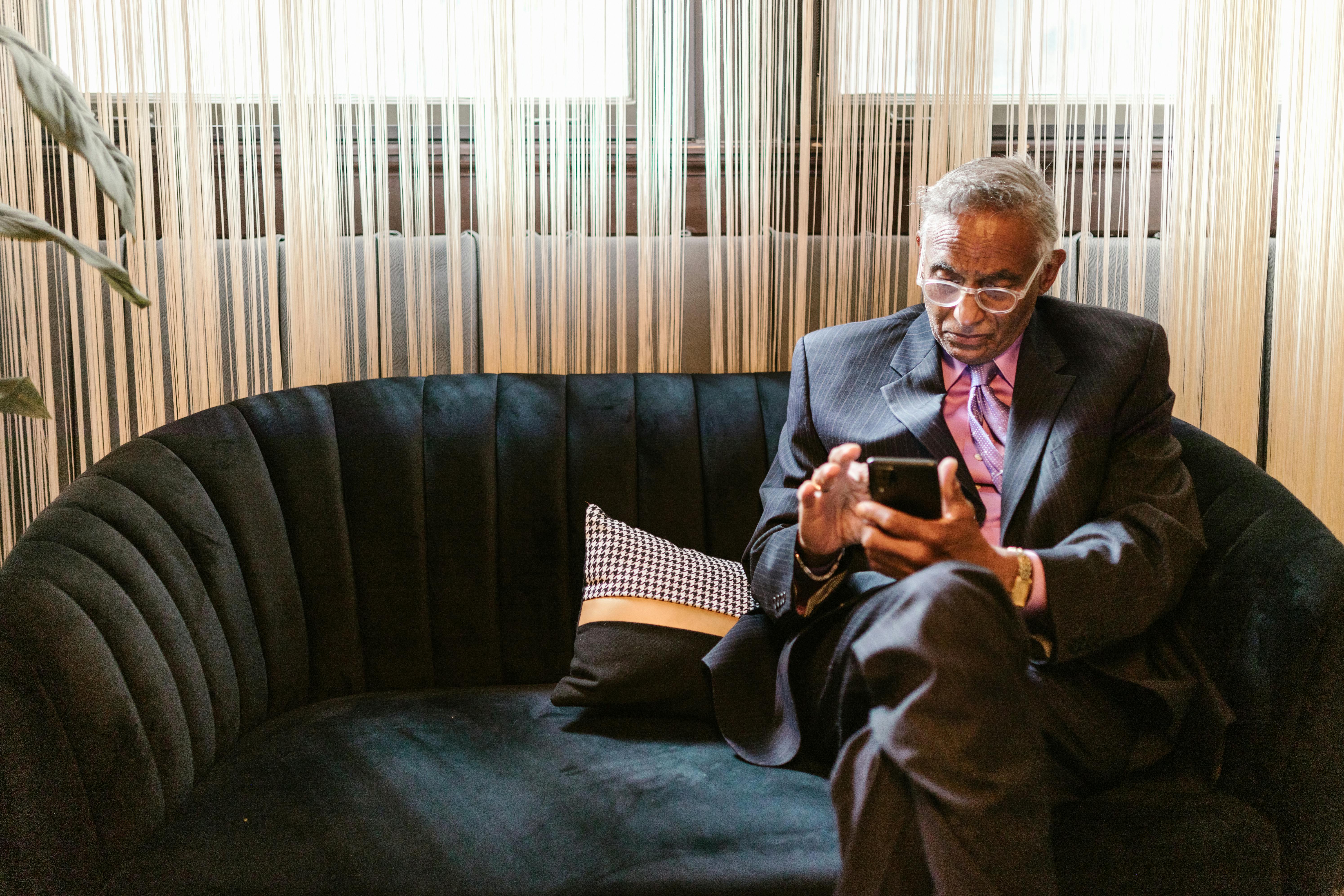 A Man in a Suit Using a Smartphone · Free Stock Photo