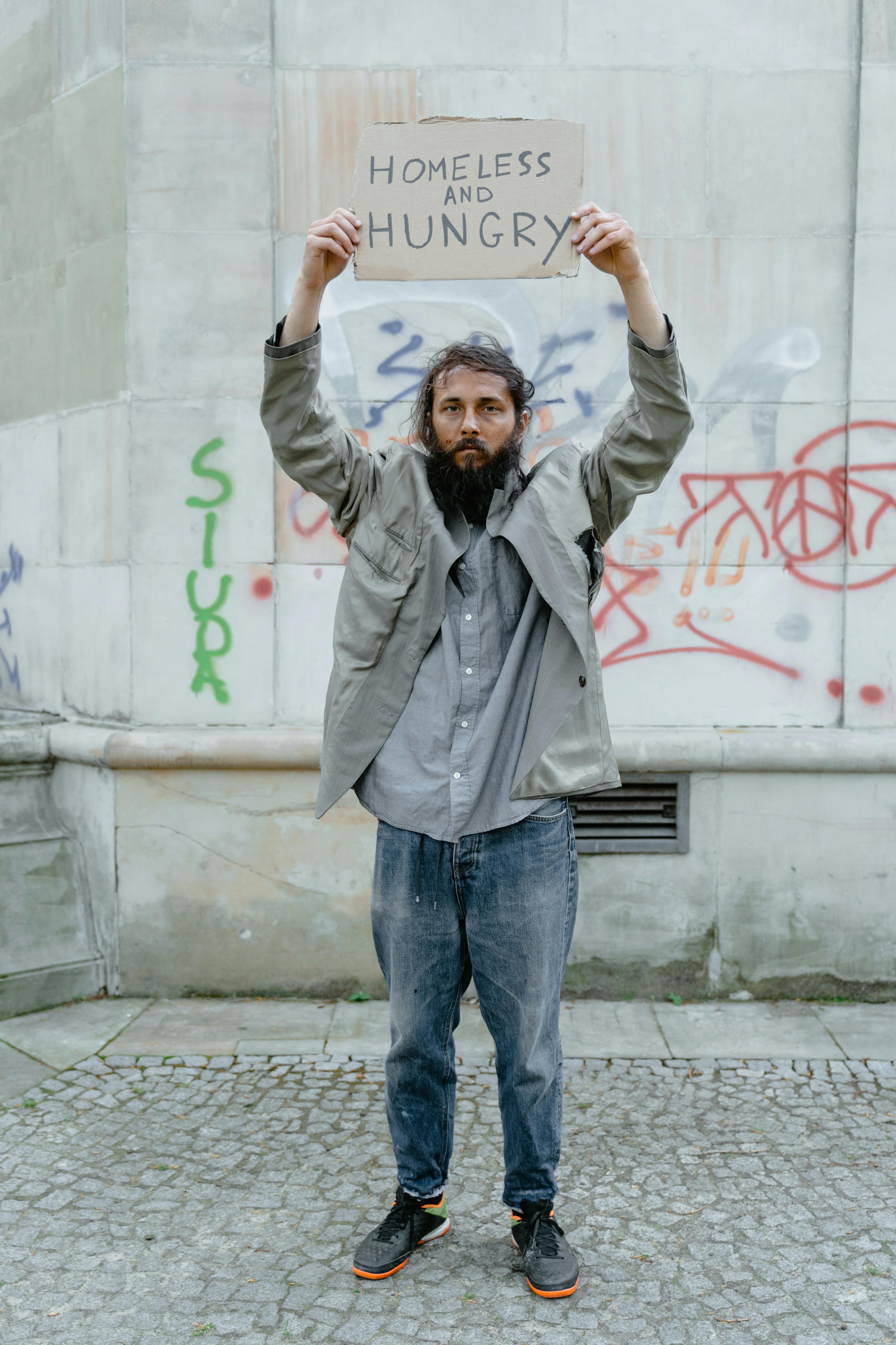 Tired and Hungry Homeless Man holding a Placard · Free Stock Photo