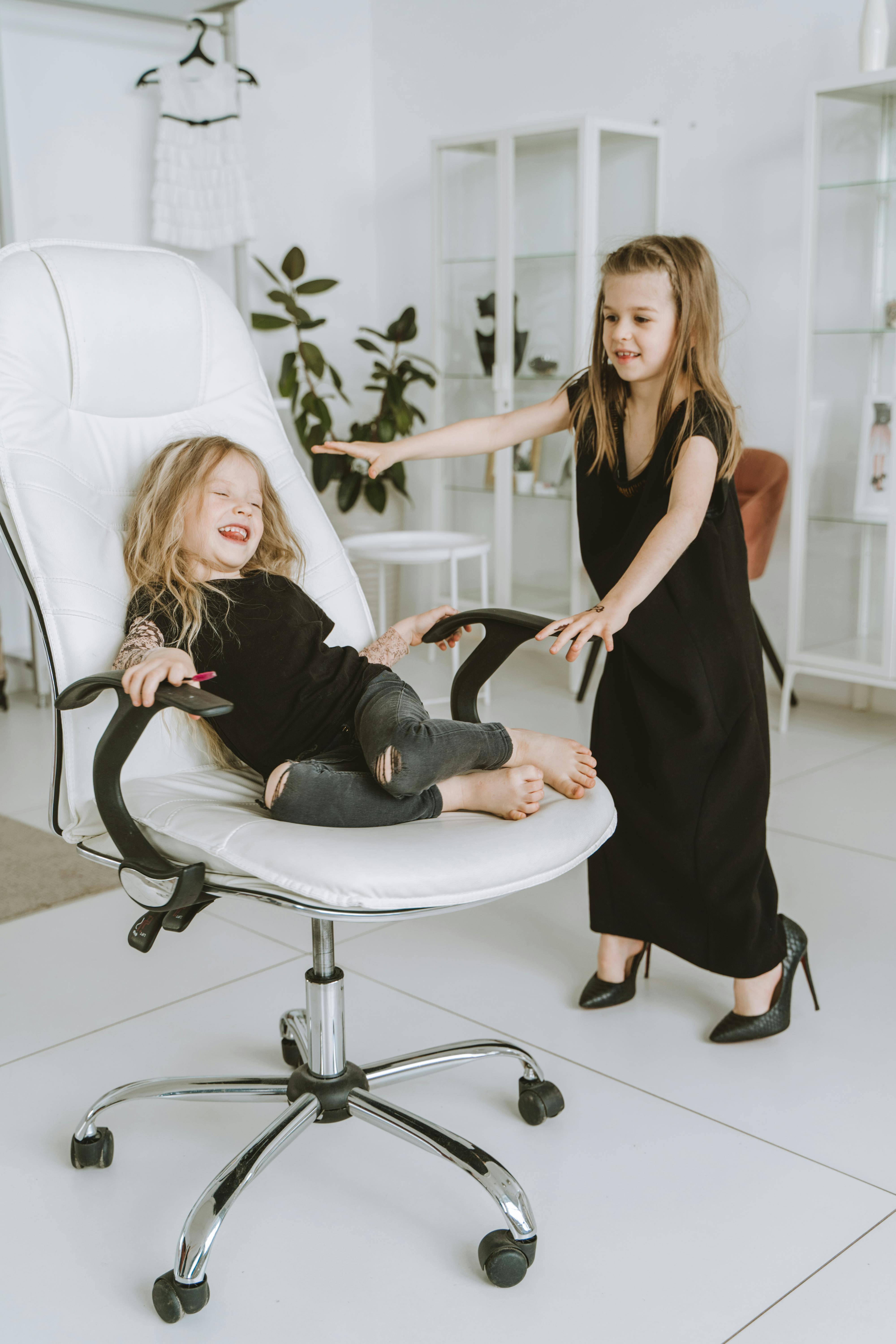 Two Girls Playing with Office Chair · Free Stock Photo