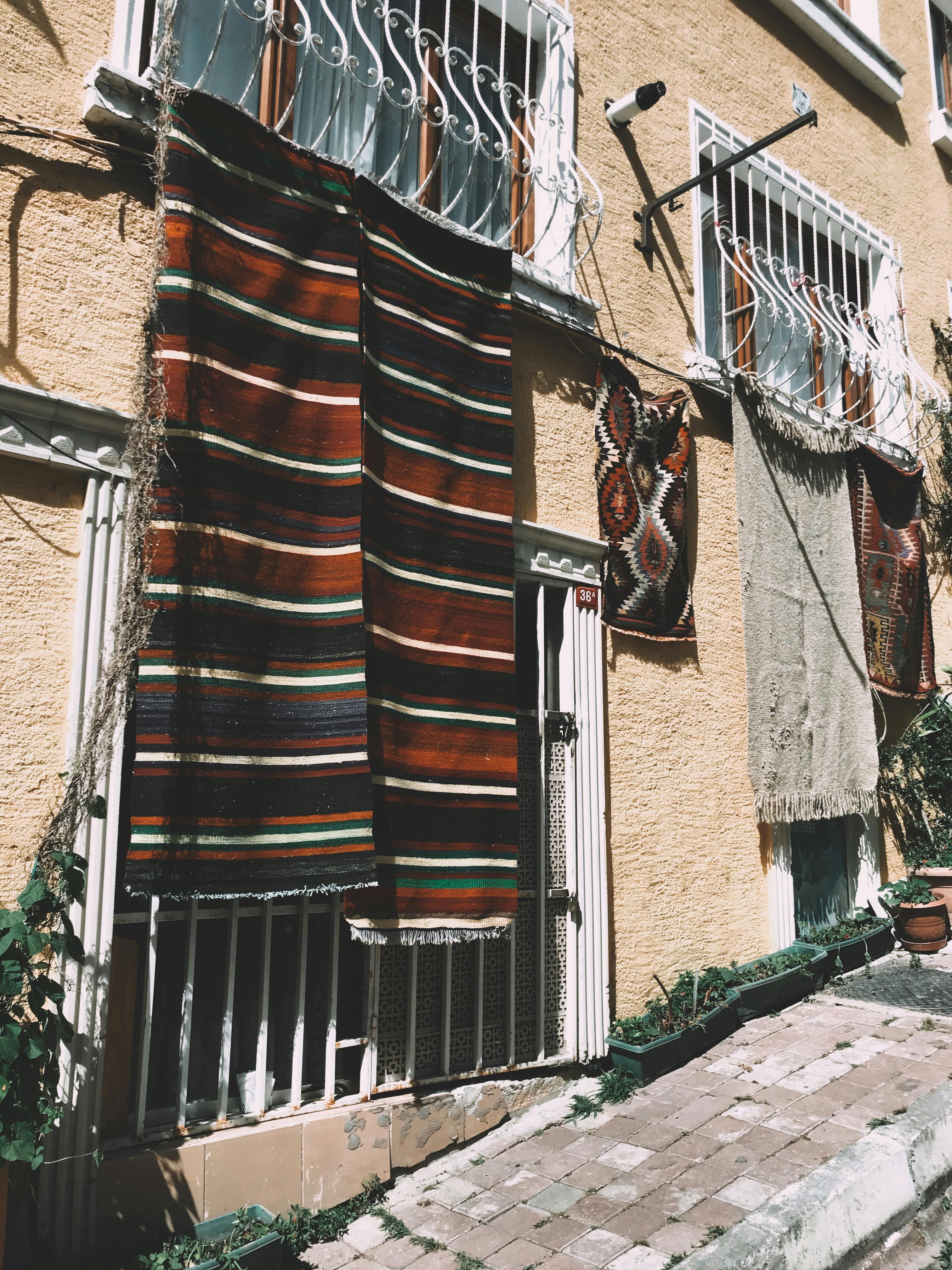 Carpets hanging on windows of residential building · Free Stock Photo