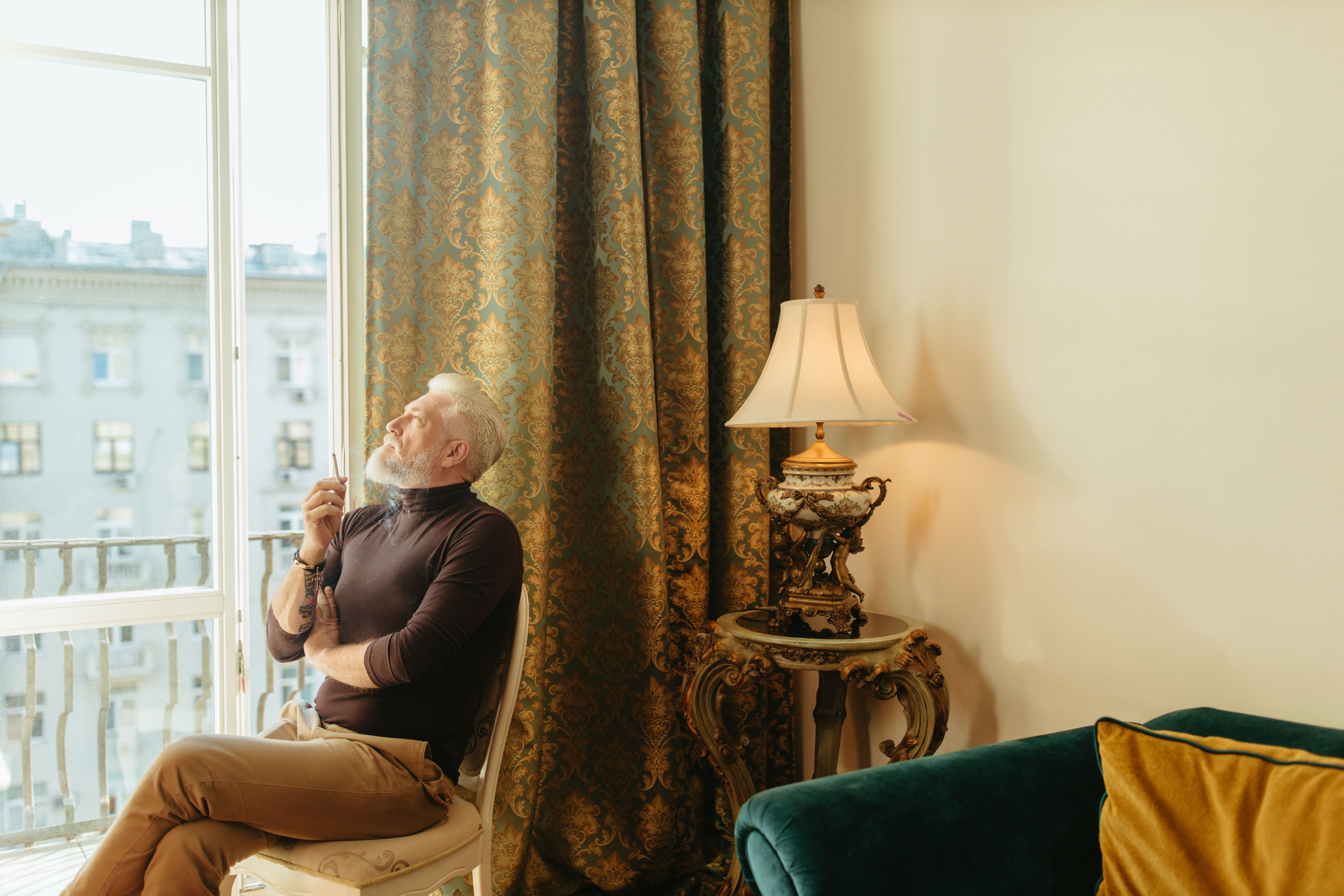 A Man Sitting While Smoking Cigarette · Free Stock Photo