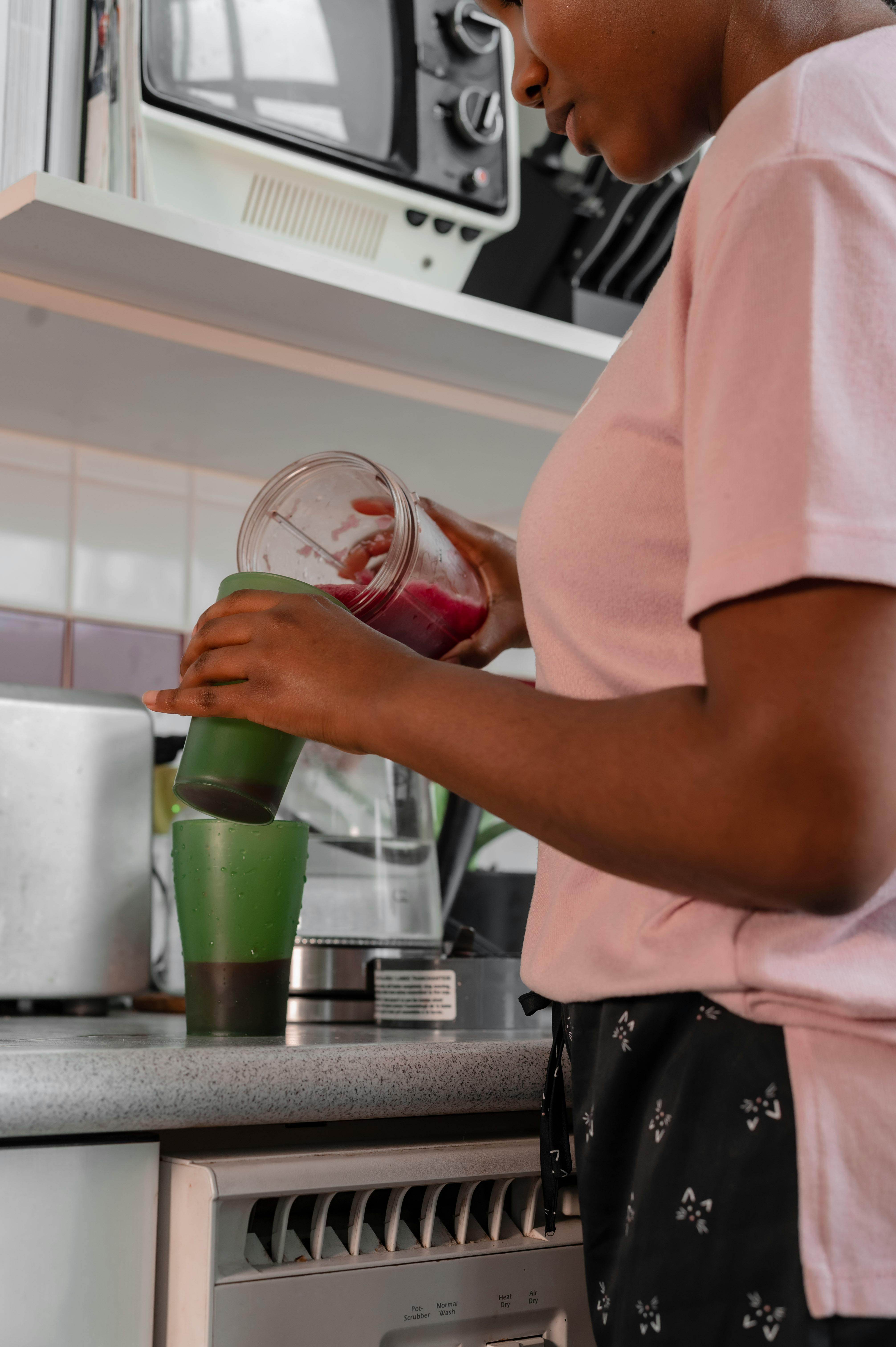 Woman Pouring Shake in Two Green Cups · Free Stock Photo