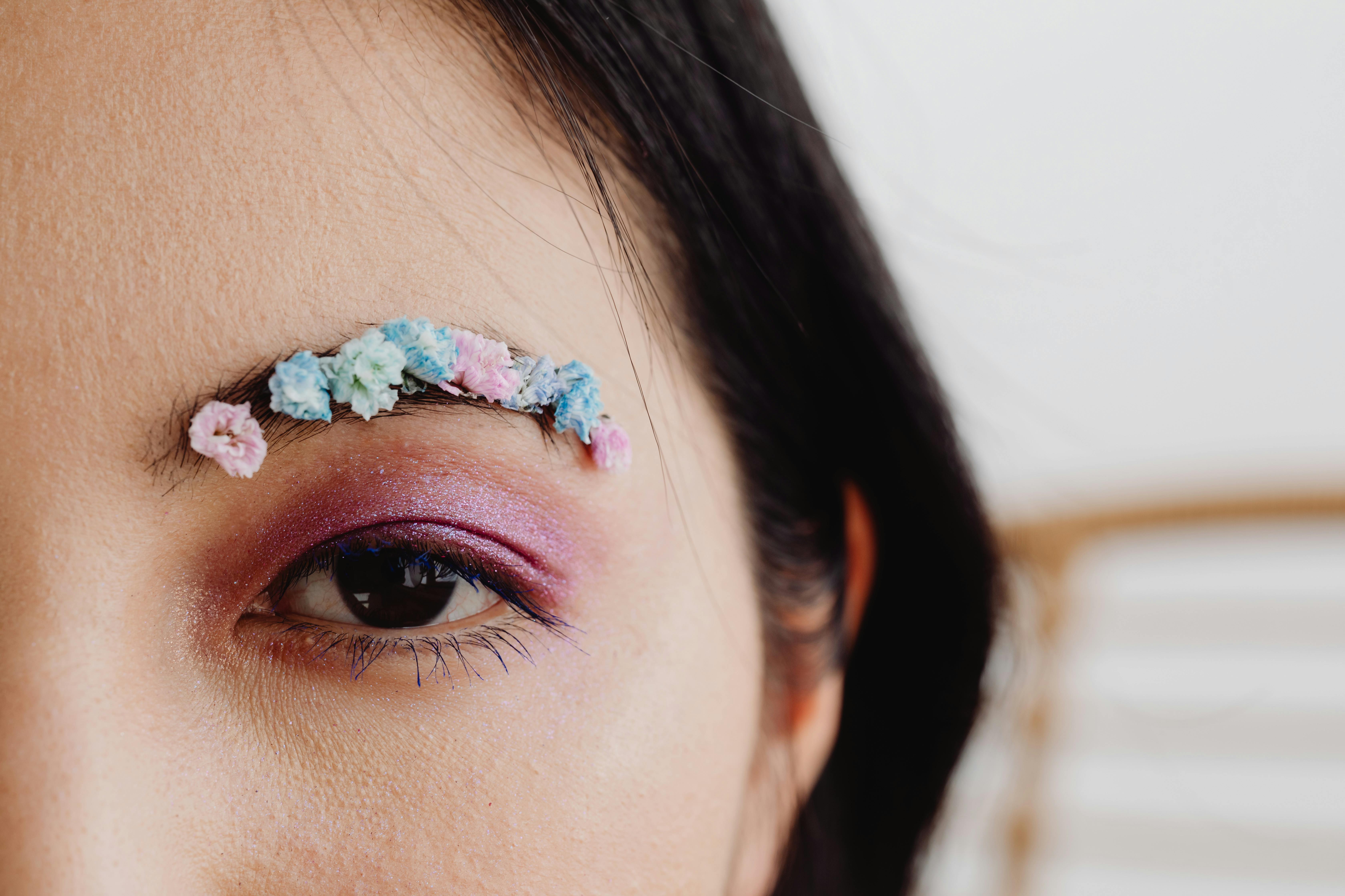 A Close-Up Shot of a Woman's Eyebrows with Small Flowers · Free Stock Photo