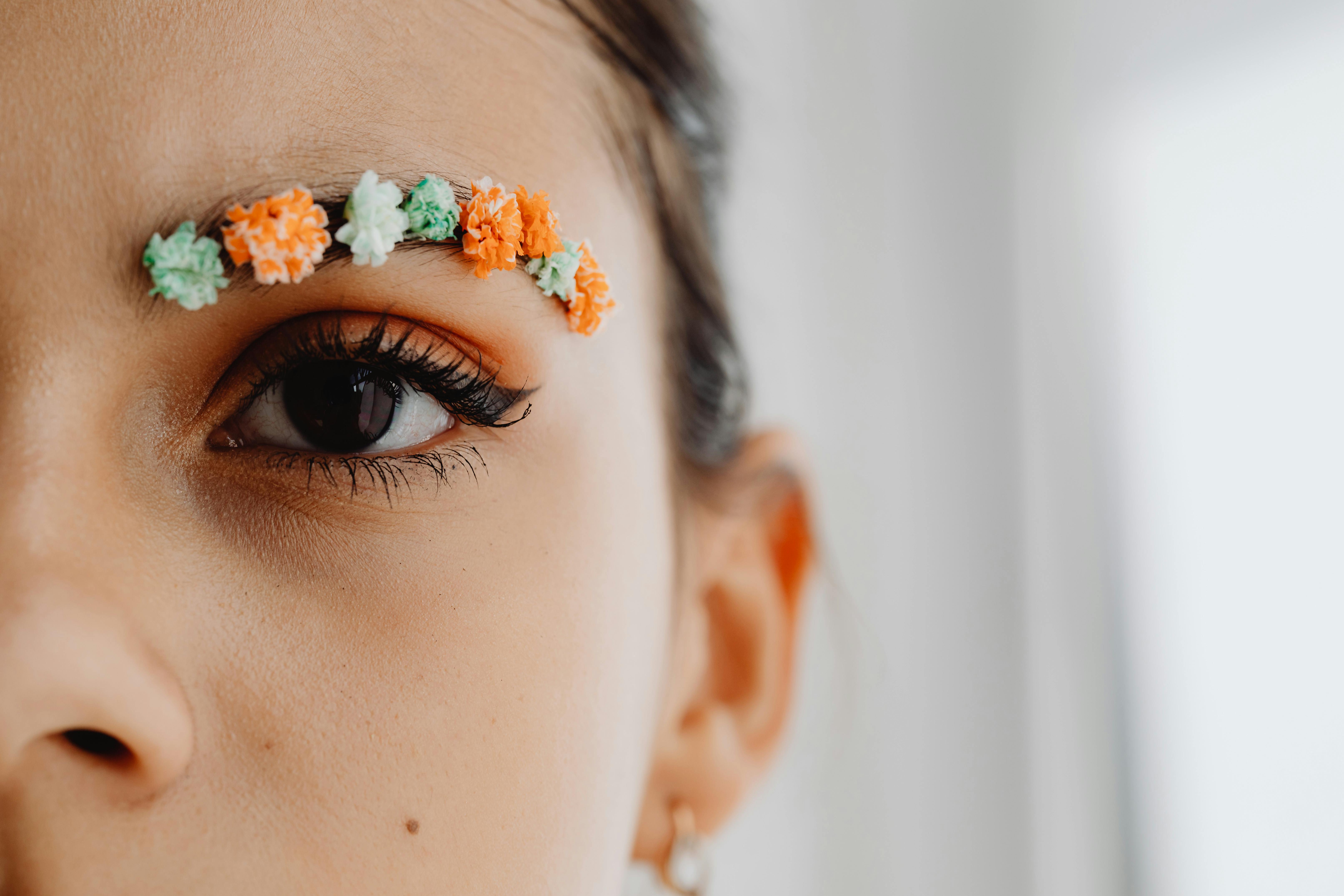 A Close-Up Shot of Woman's Eyebrow with Small Flowers · Free Stock Photo