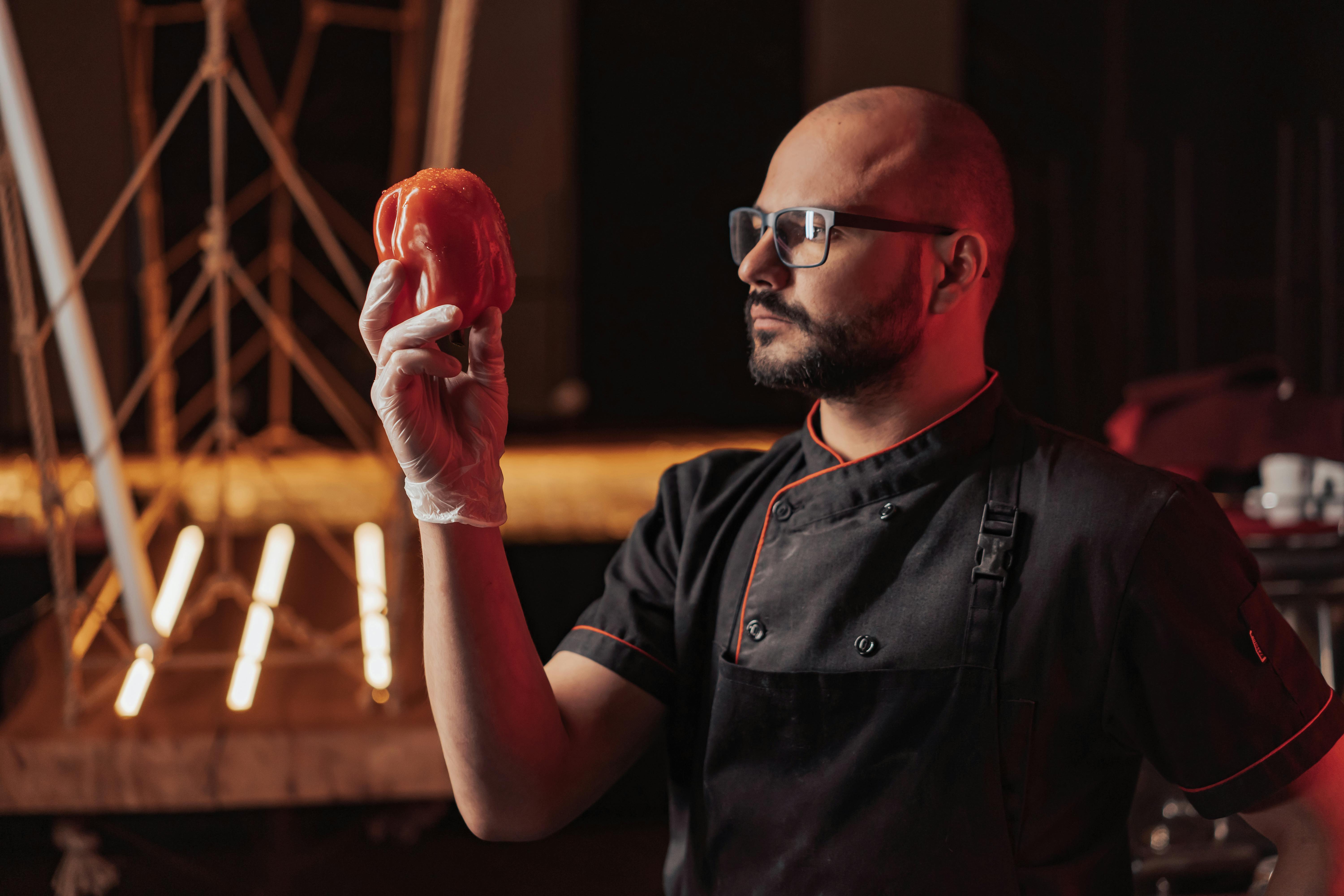 Chef in Black Uniform Looking at a Bell Pepper · Free Stock Photo