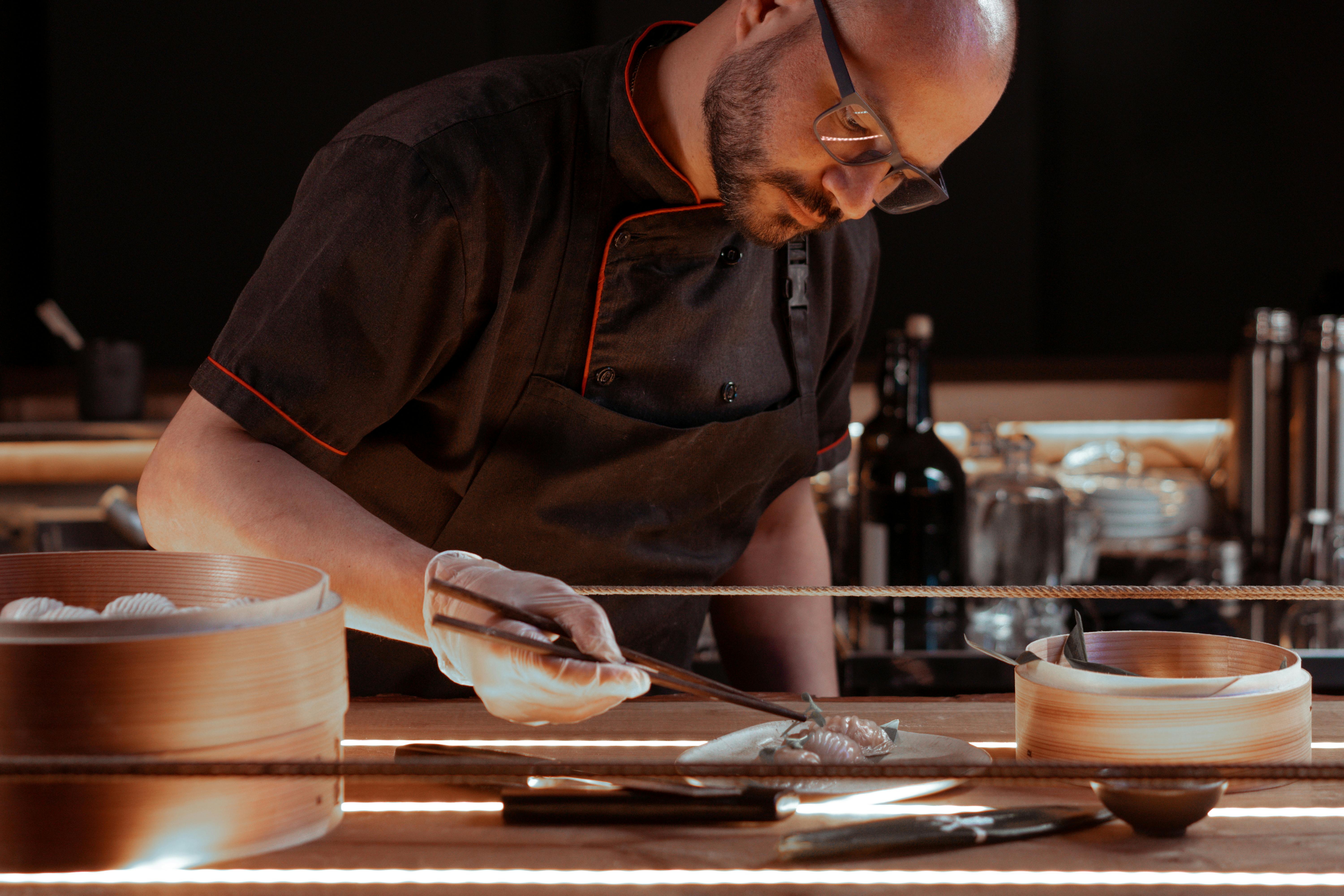 Man Arranging Dumplings on a Food Tray · Free Stock Photo