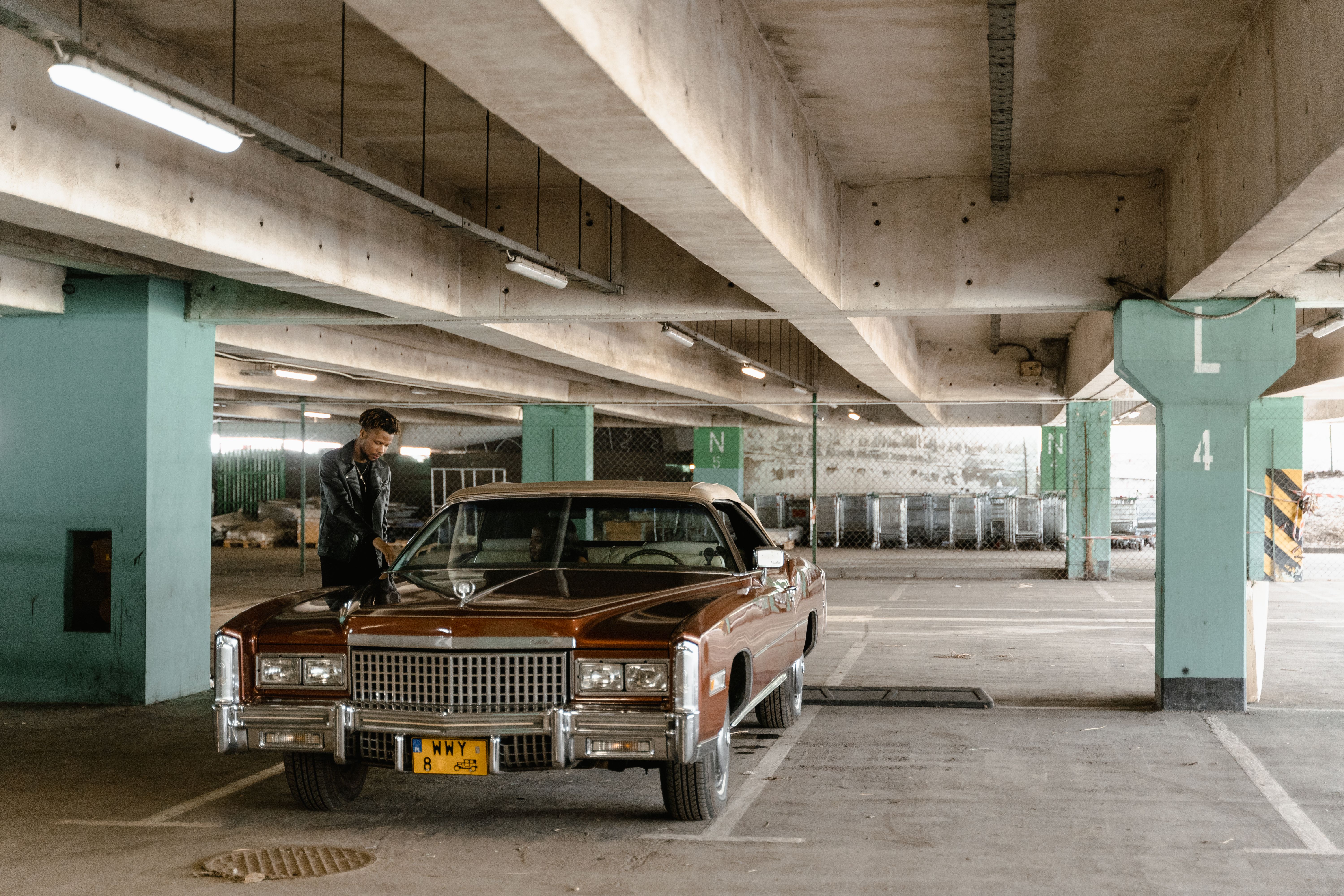 A Man Standing Beside the Brown Car · Free Stock Photo