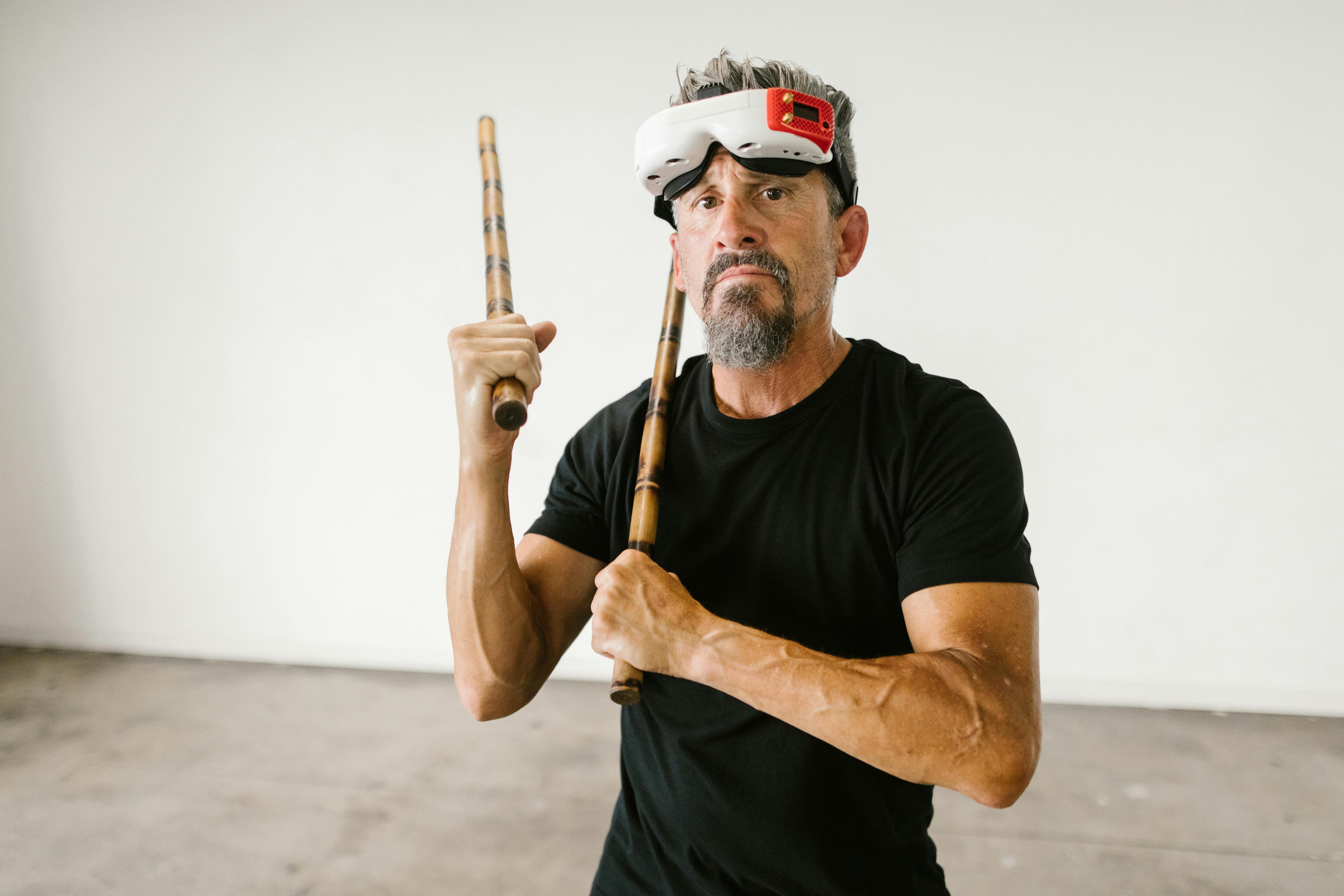 A Man Holding Wooden Sticks · Free Stock Photo