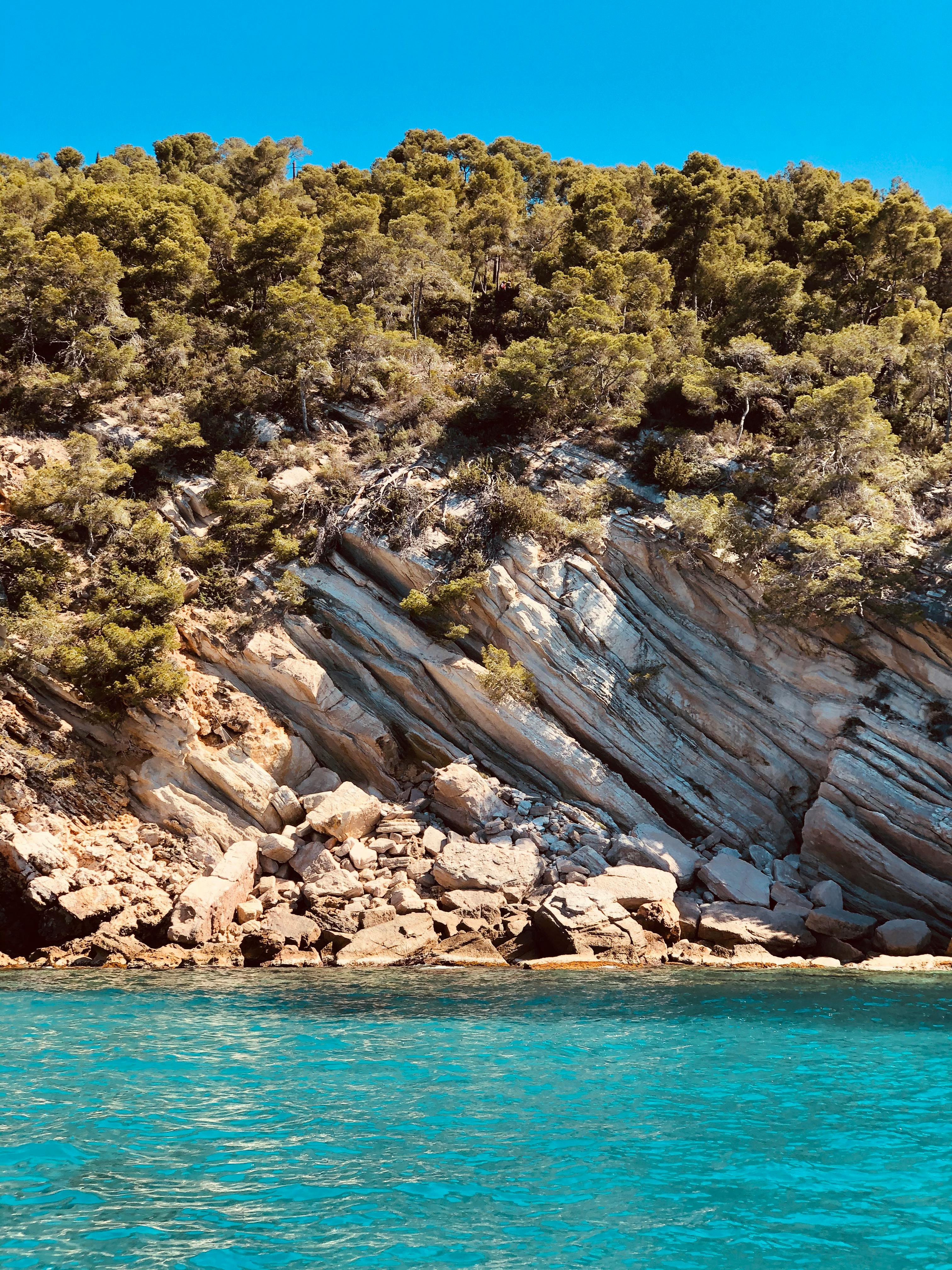 Soaring Rock Formation Photographed from Sea · Free Stock Photo