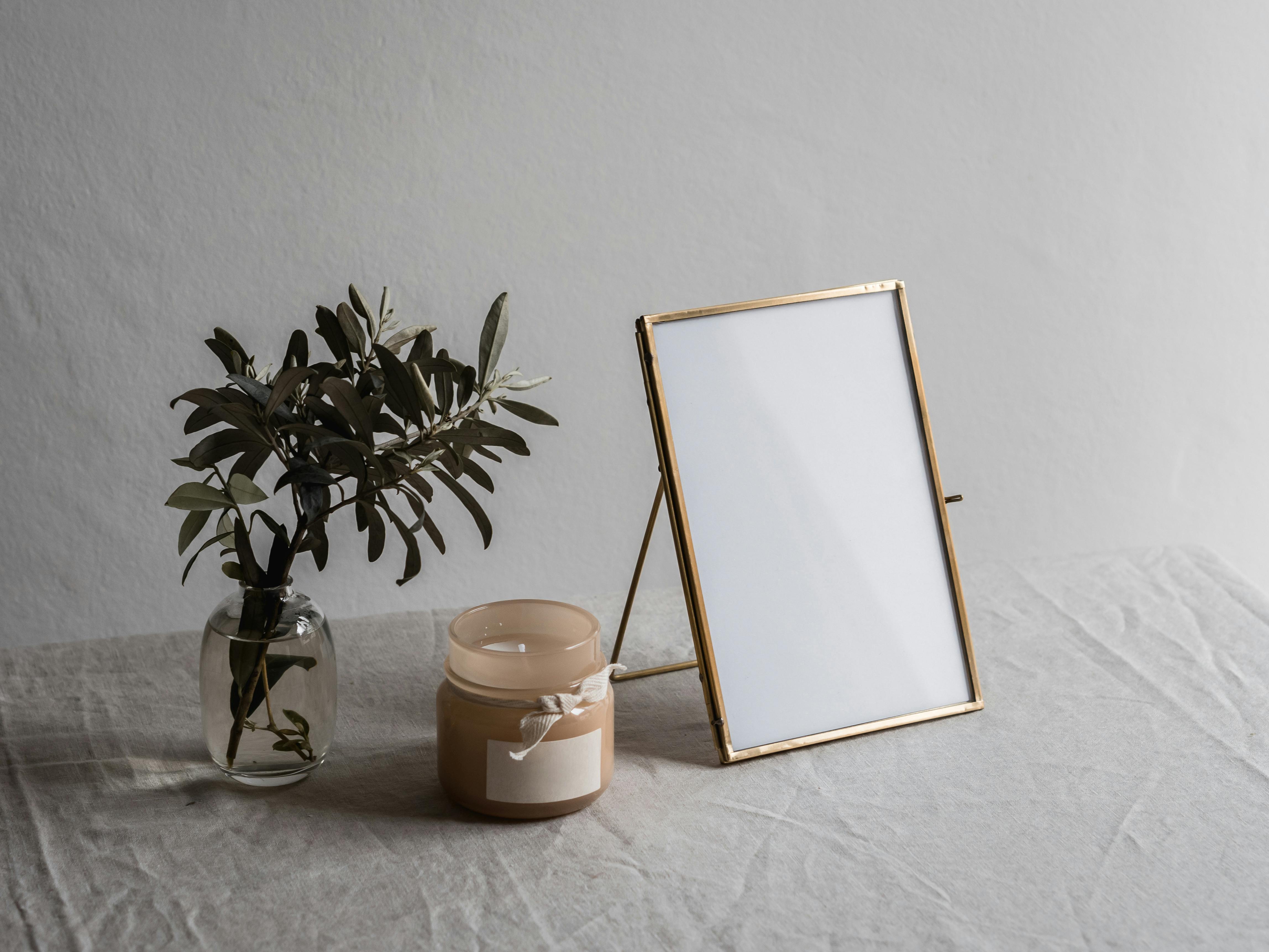 White Photo Frame beside a Container on a White Fabric · Free Stock Photo