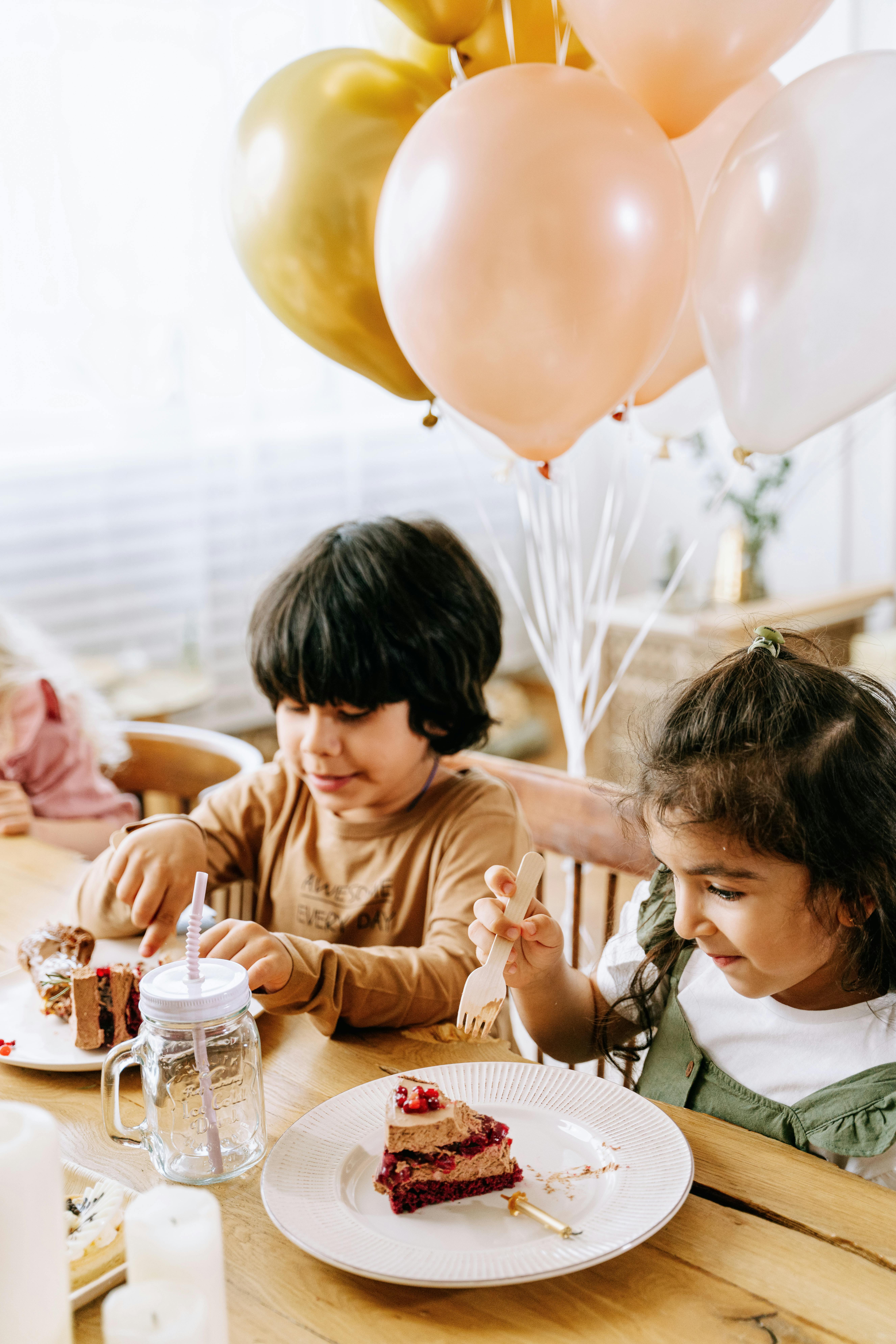 Children Eating Cake while Sitting at a Table · Free Stock Photo