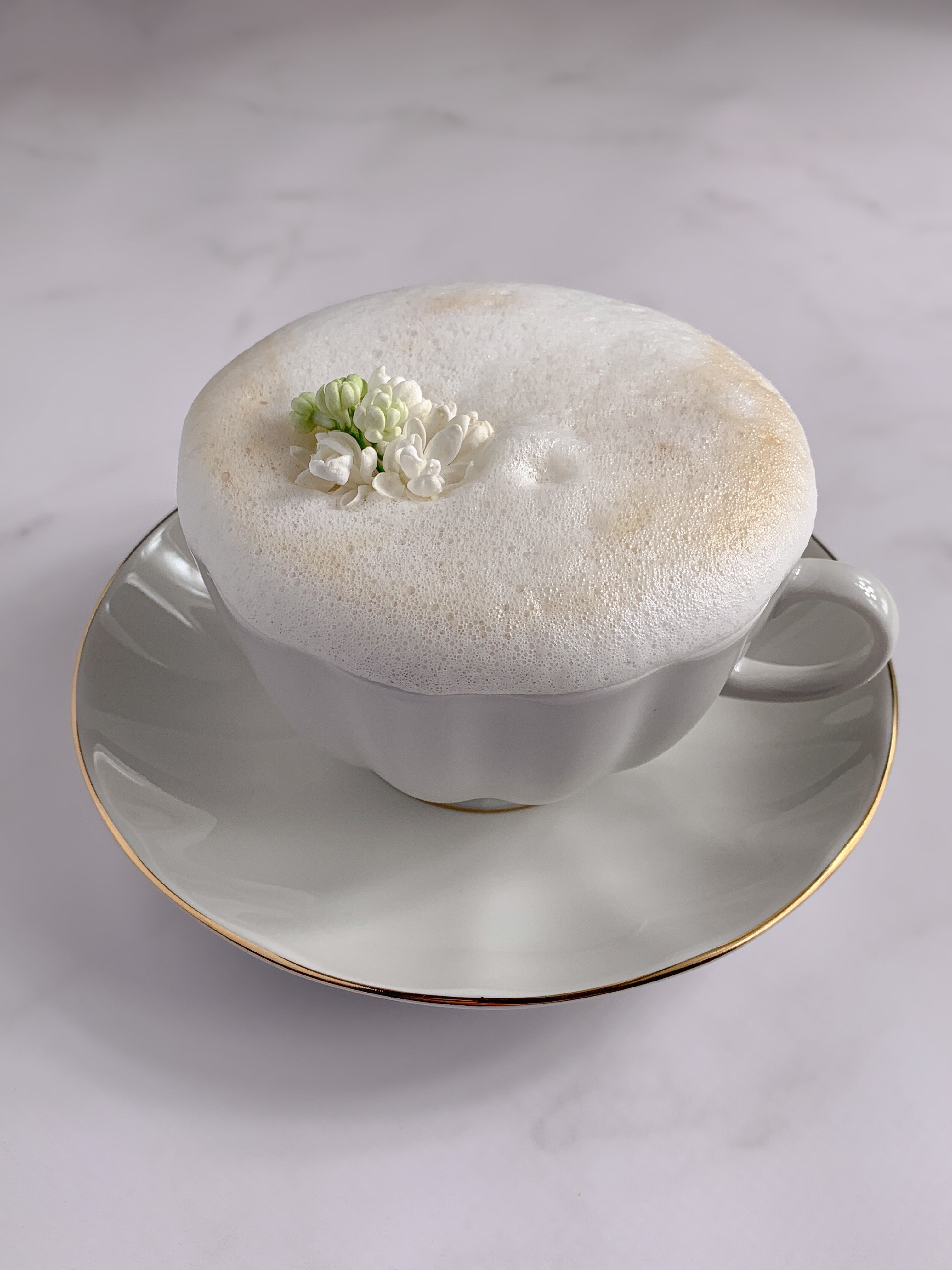 White Flower on White Foamy Coffee in White Porcelain Cup and Saucer ...