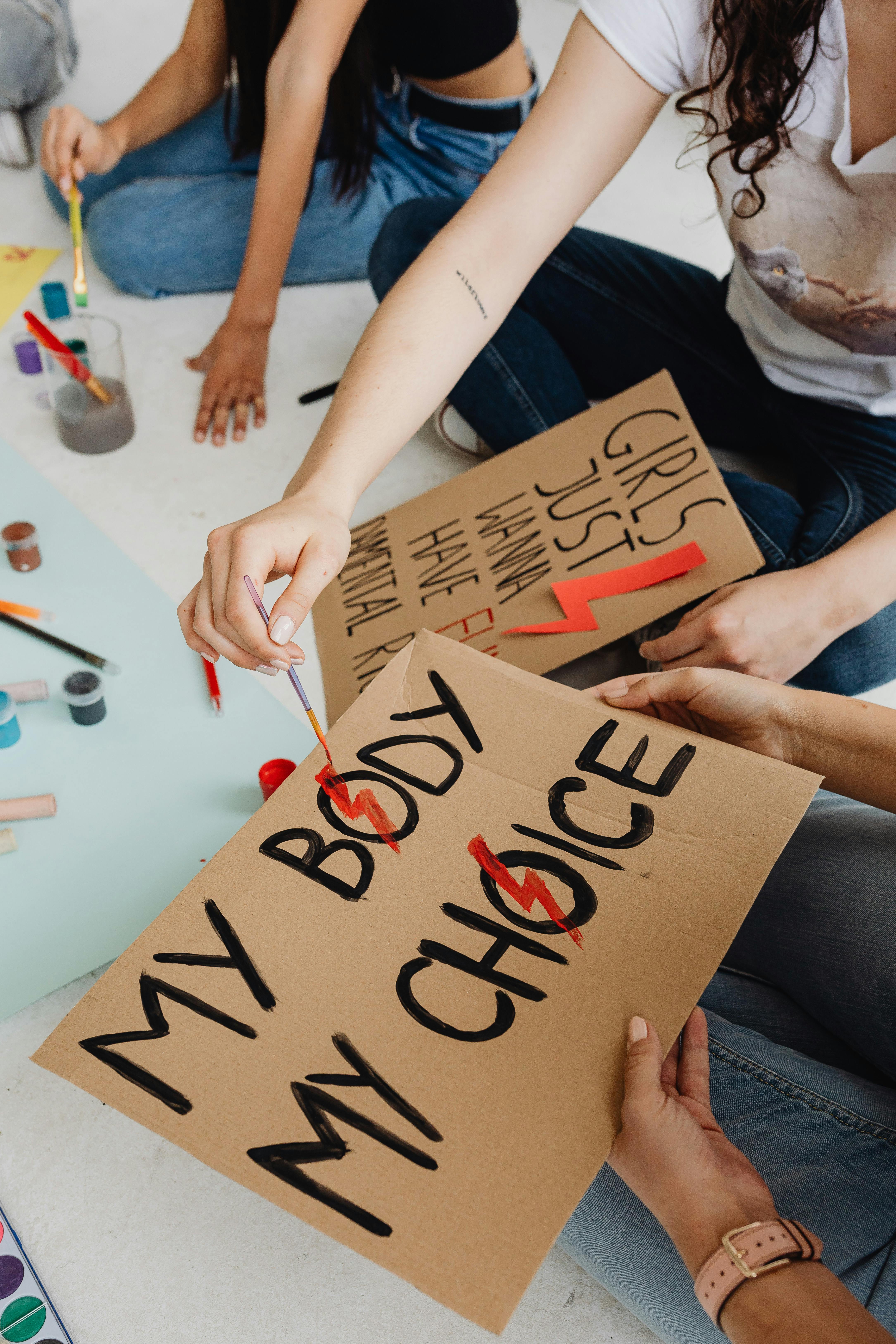 Women Sitting and Writing Banners · Free Stock Photo