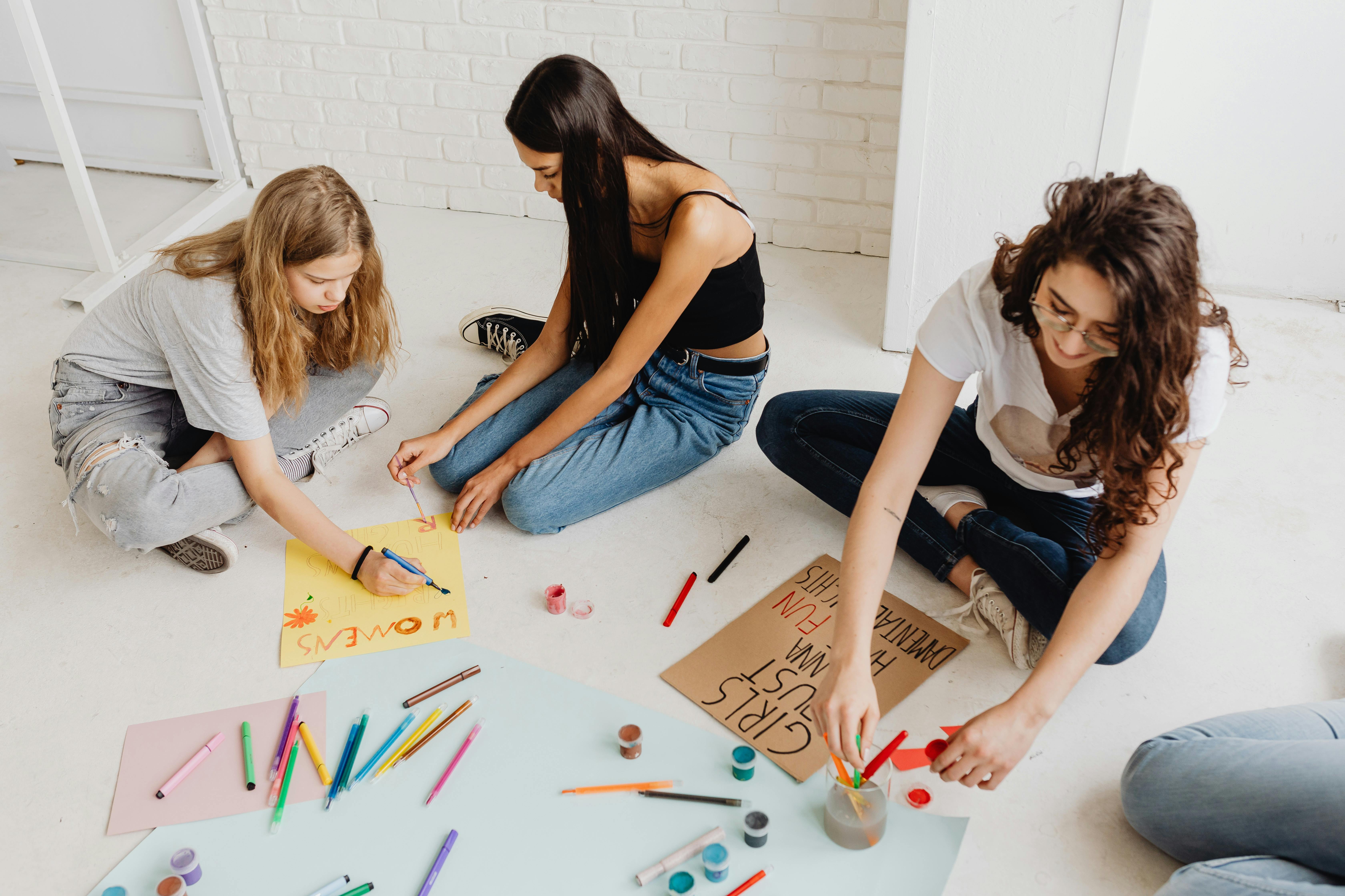 Women Writing on Placards while Sitting on the Floor · Free Stock Photo