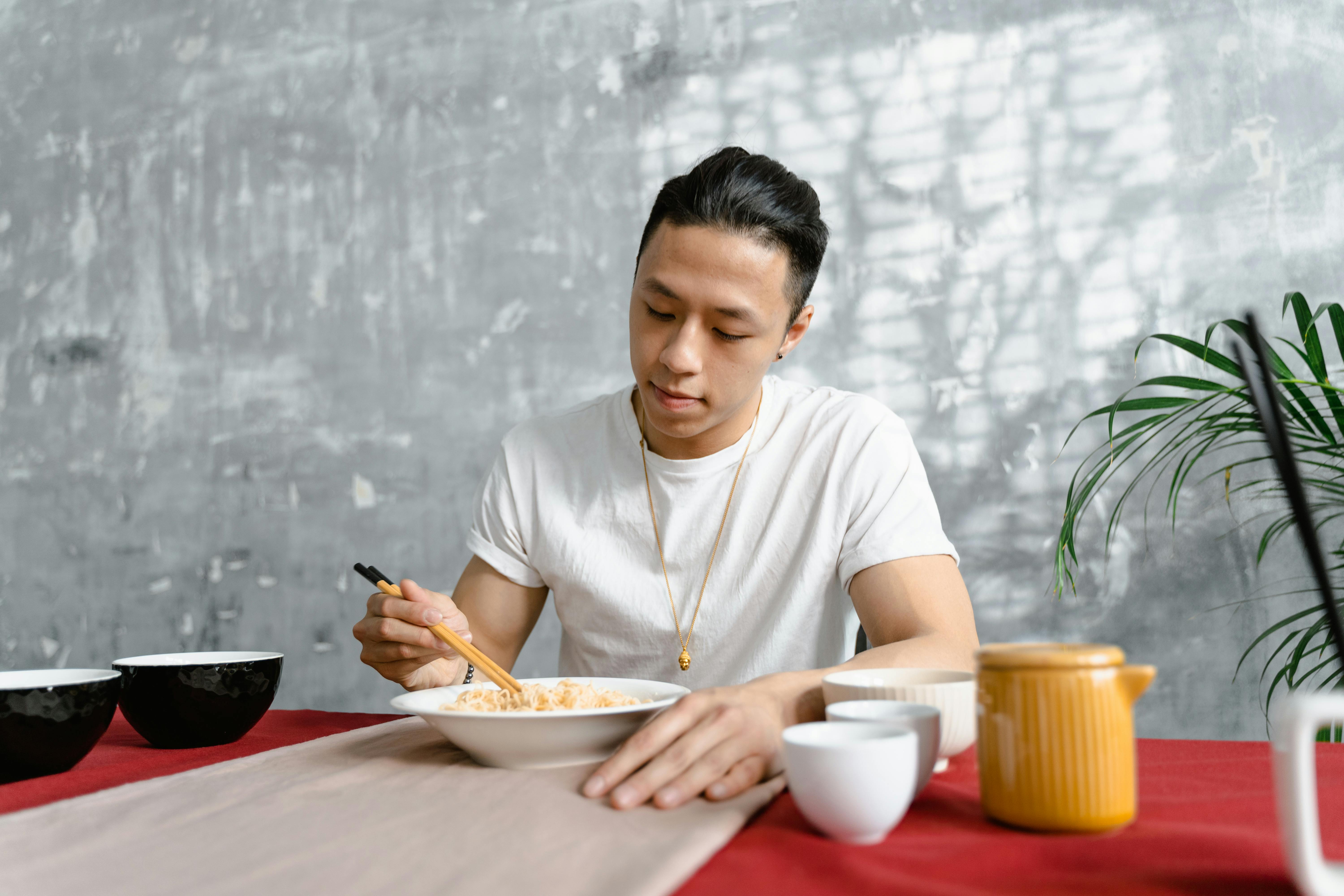 Man in White Short Eating with Chopsticks · Free Stock Photo