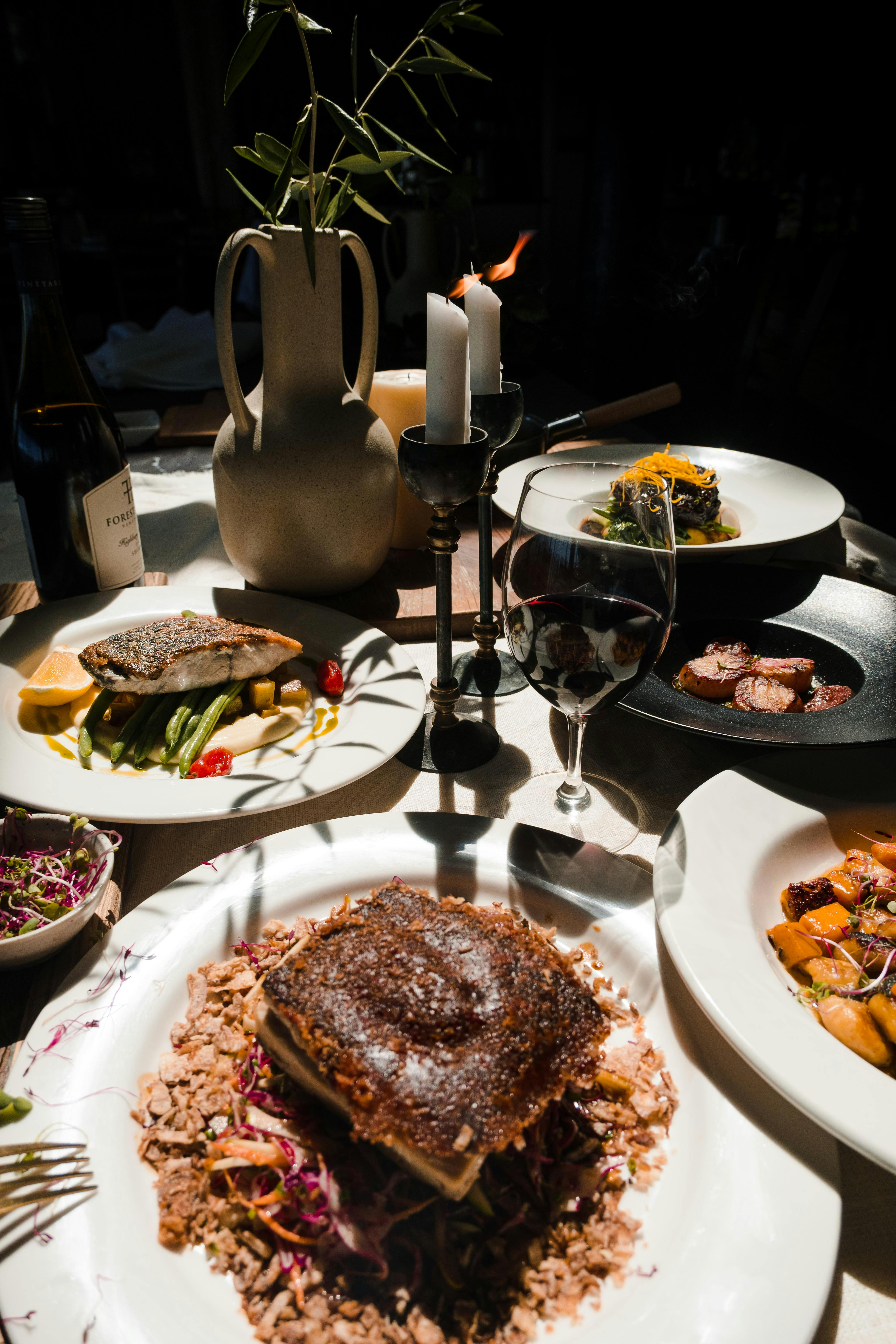 Various Gourmet Dishes on a Dining Table · Free Stock Photo