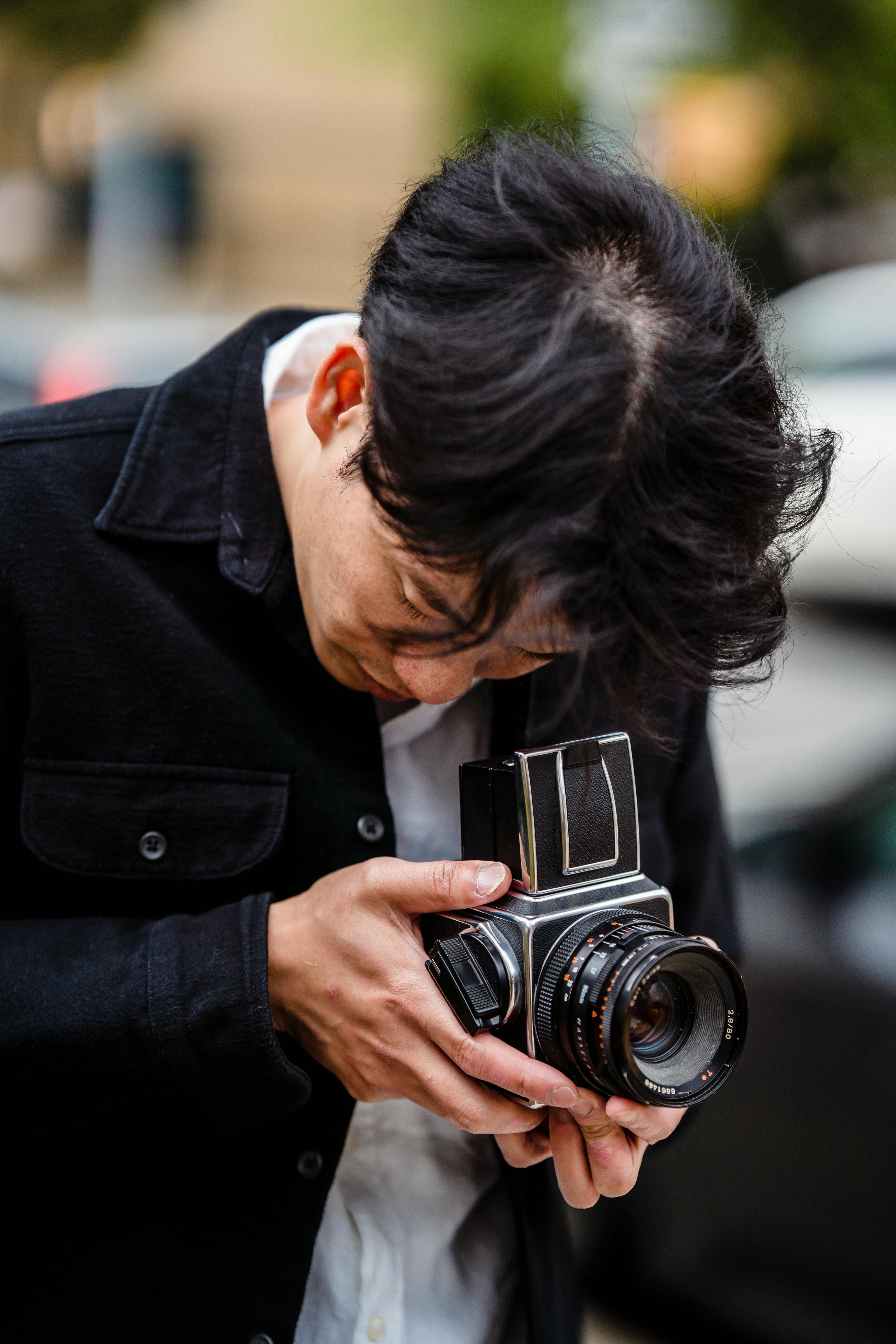 A Man using a Vintage Camera while Taking Pictures · Free Stock Photo