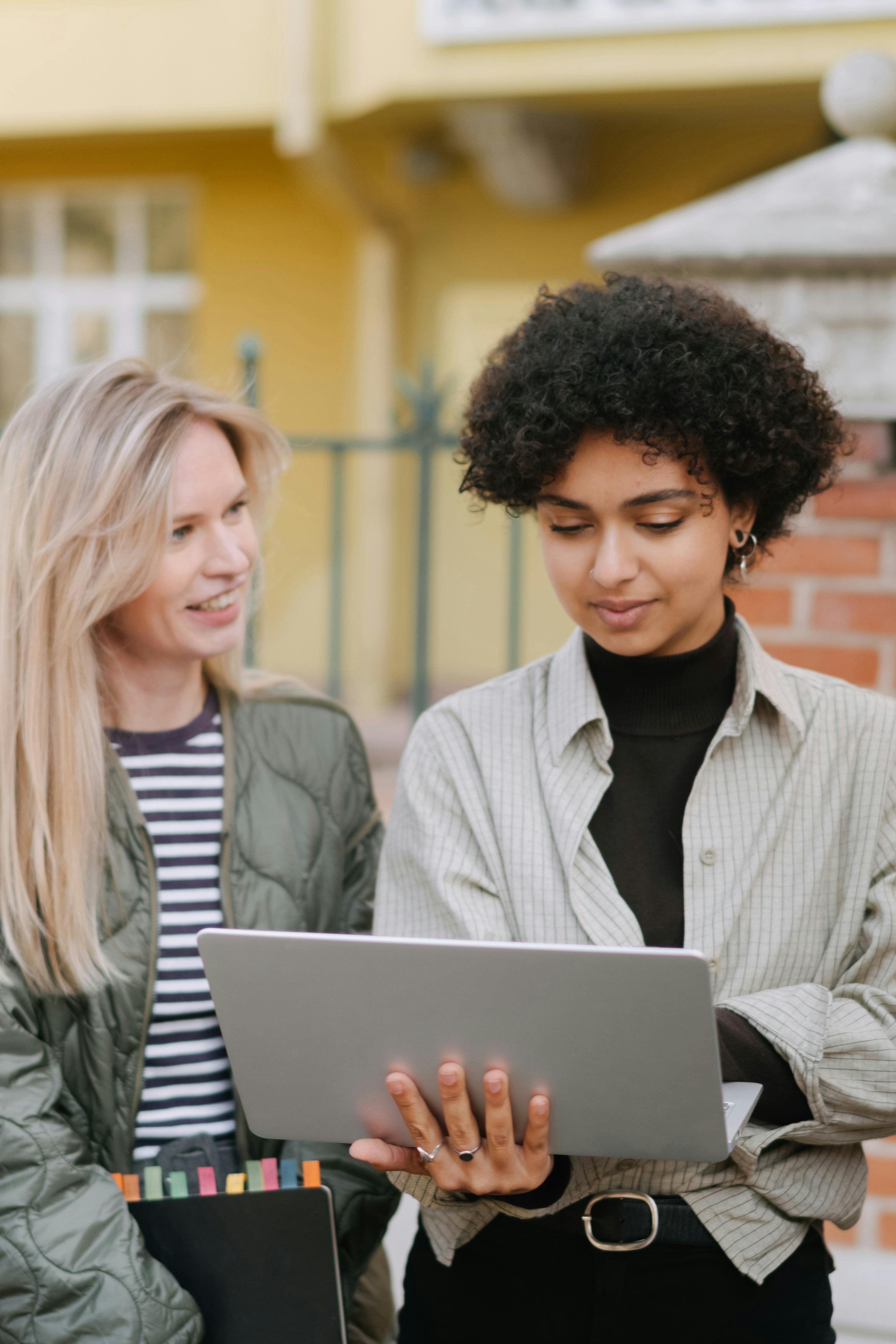 Women Holding Laptop on a Street · Free Stock Photo