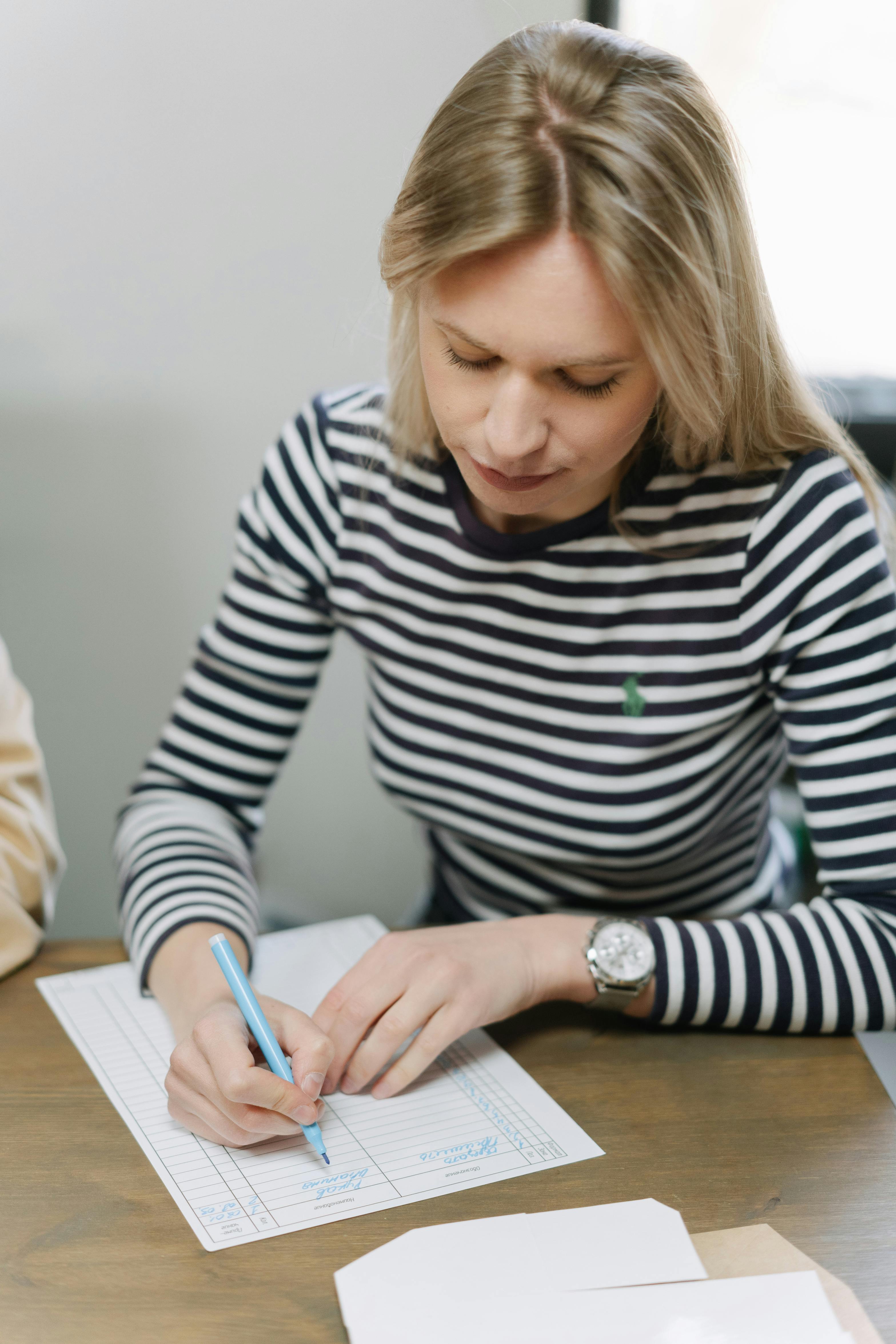 A Woman Writing on the Paper · Free Stock Photo