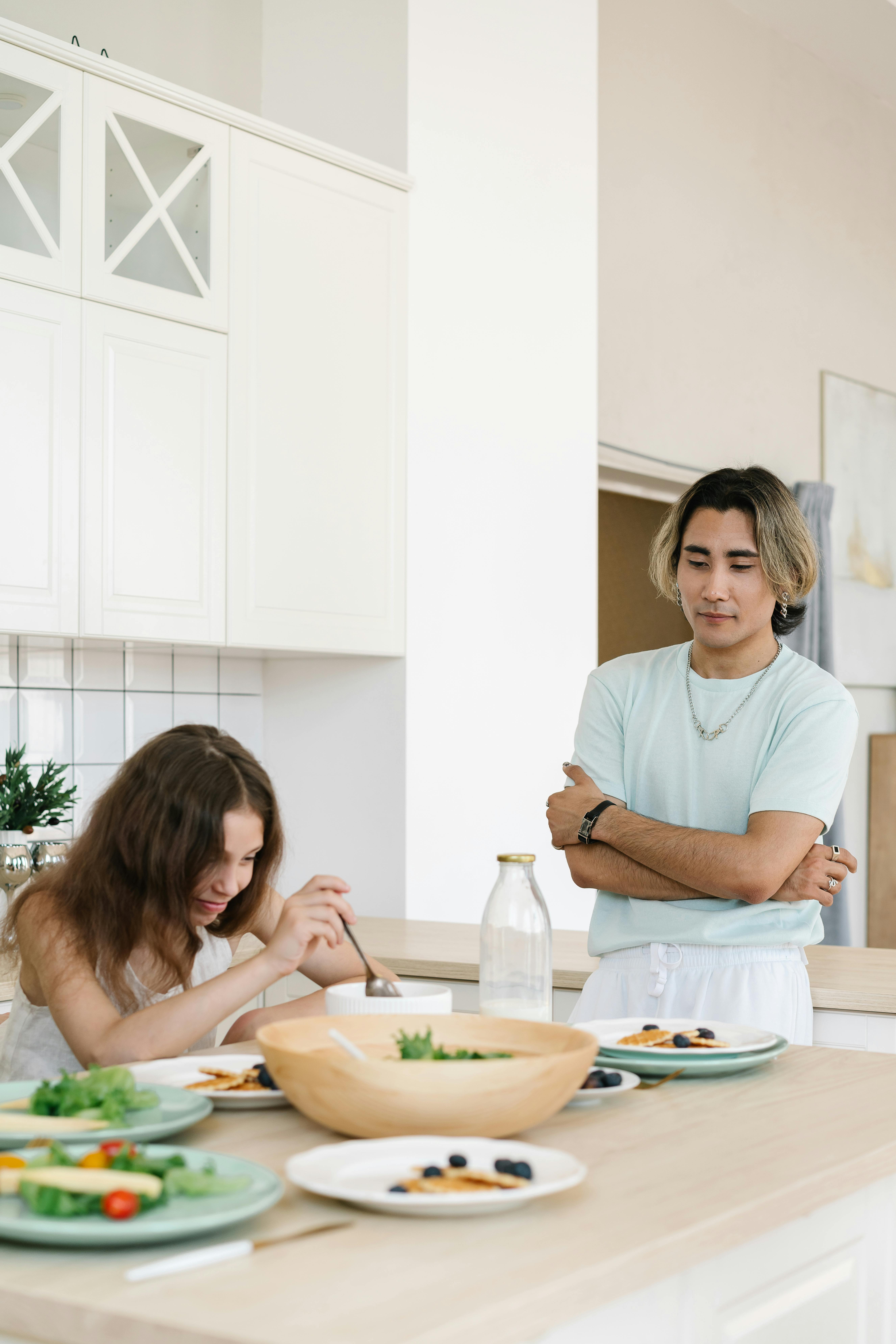 A Father Staring at His Daughter Eating Breakfast · Free Stock Photo
