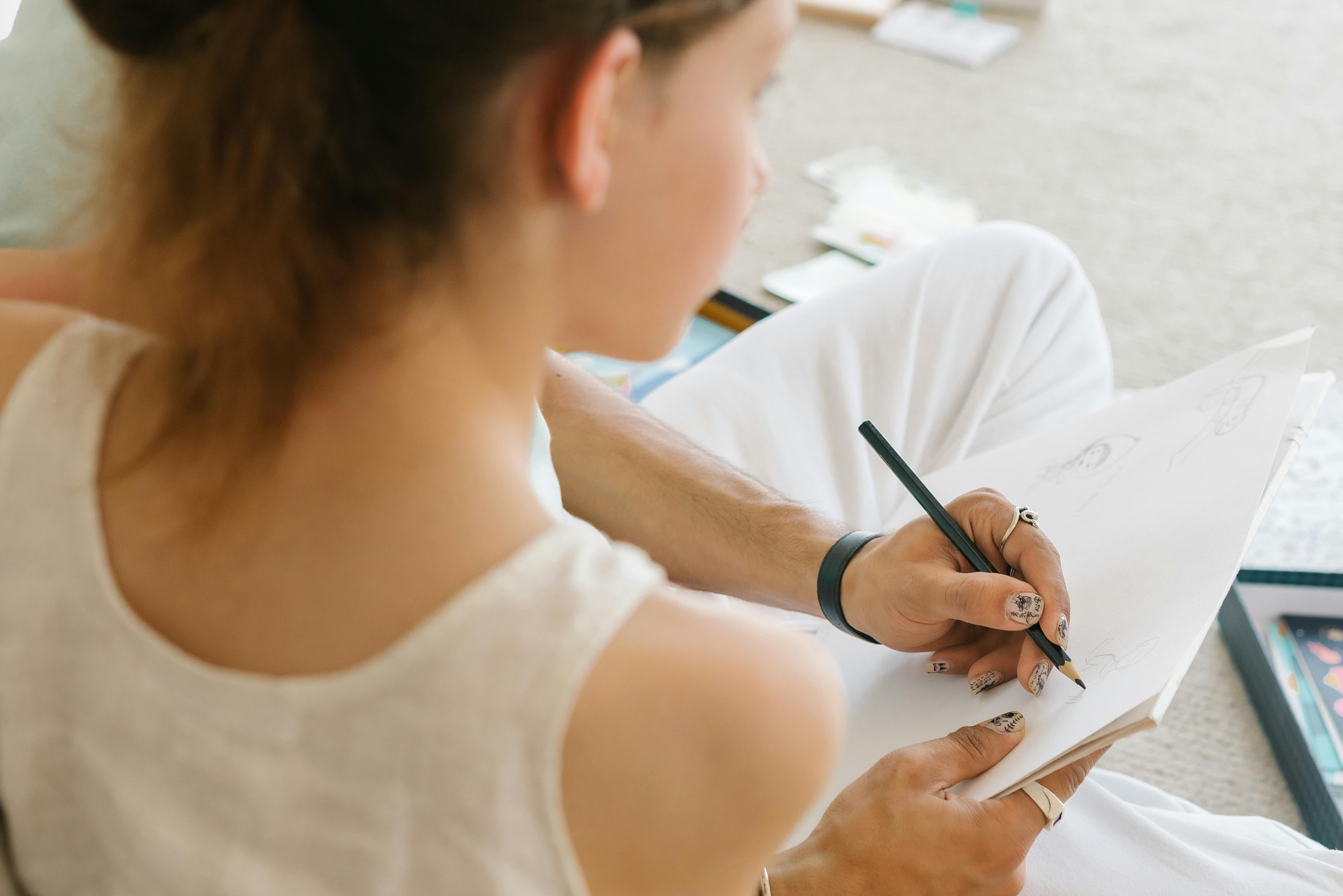 A Person Doing Drawing using a White Paper · Free Stock Photo