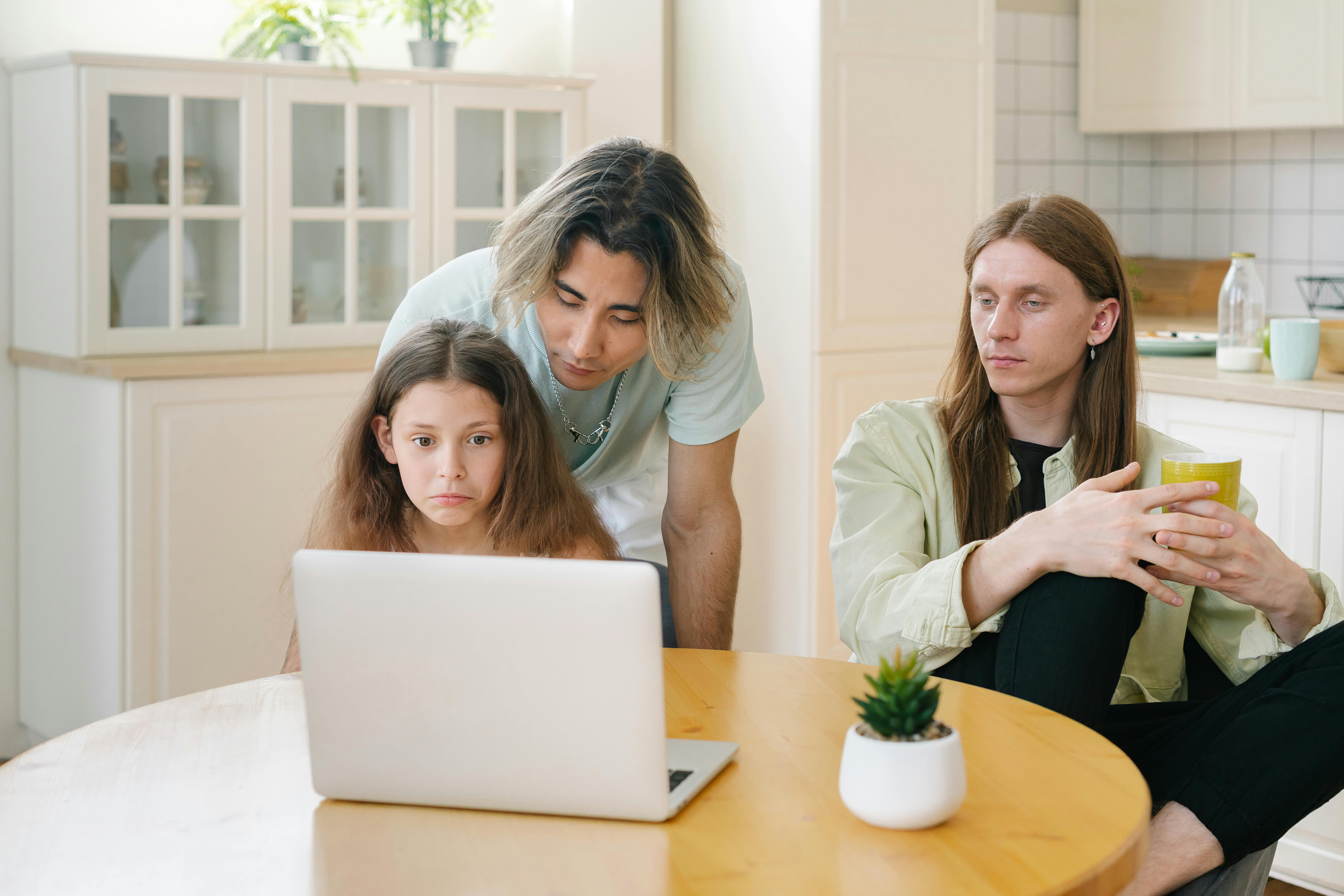 A Happy Family Looking at the Screen of a Laptop · Free Stock Photo