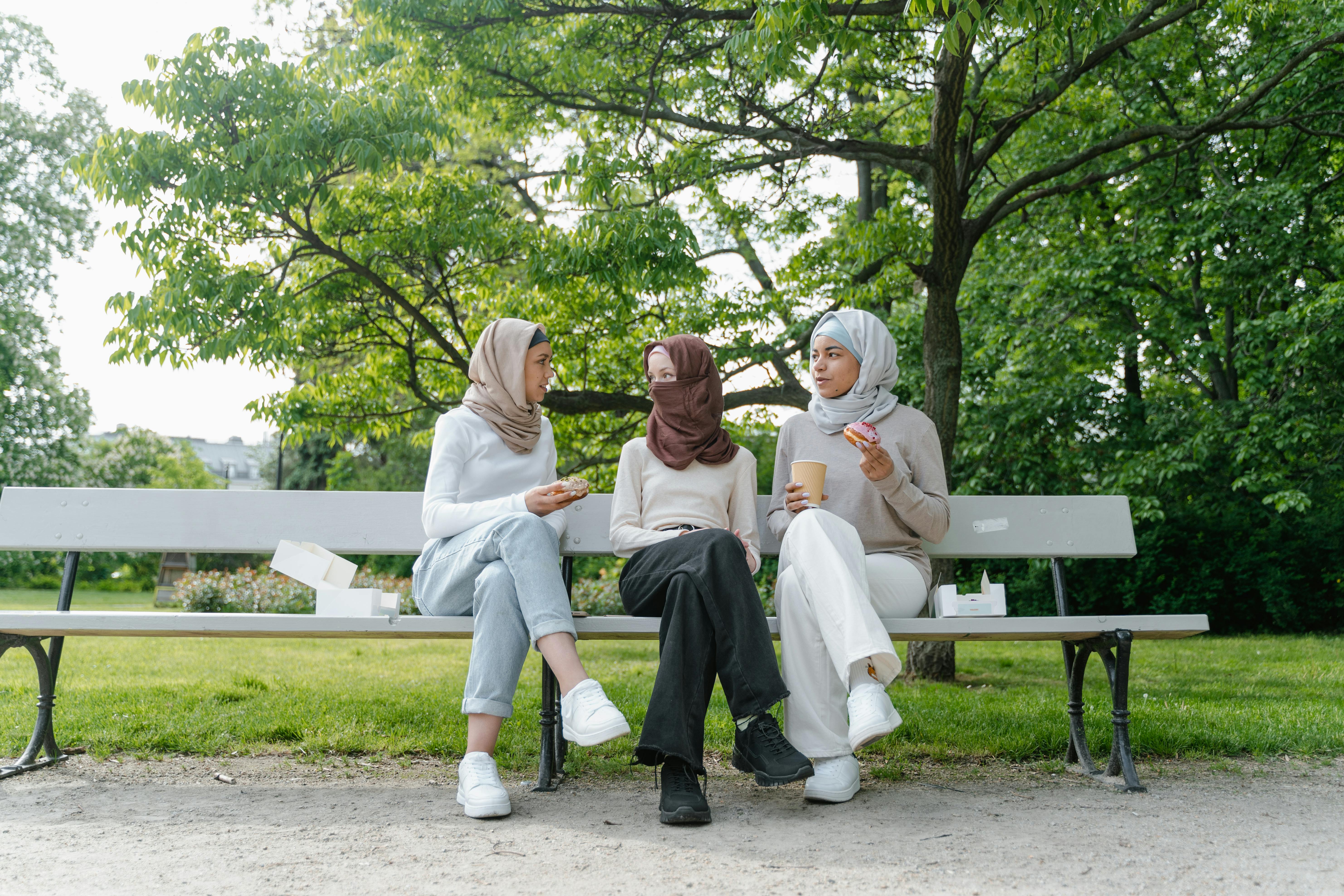 Women Talking to One Another While Sitting on a Bench · Free Stock Photo