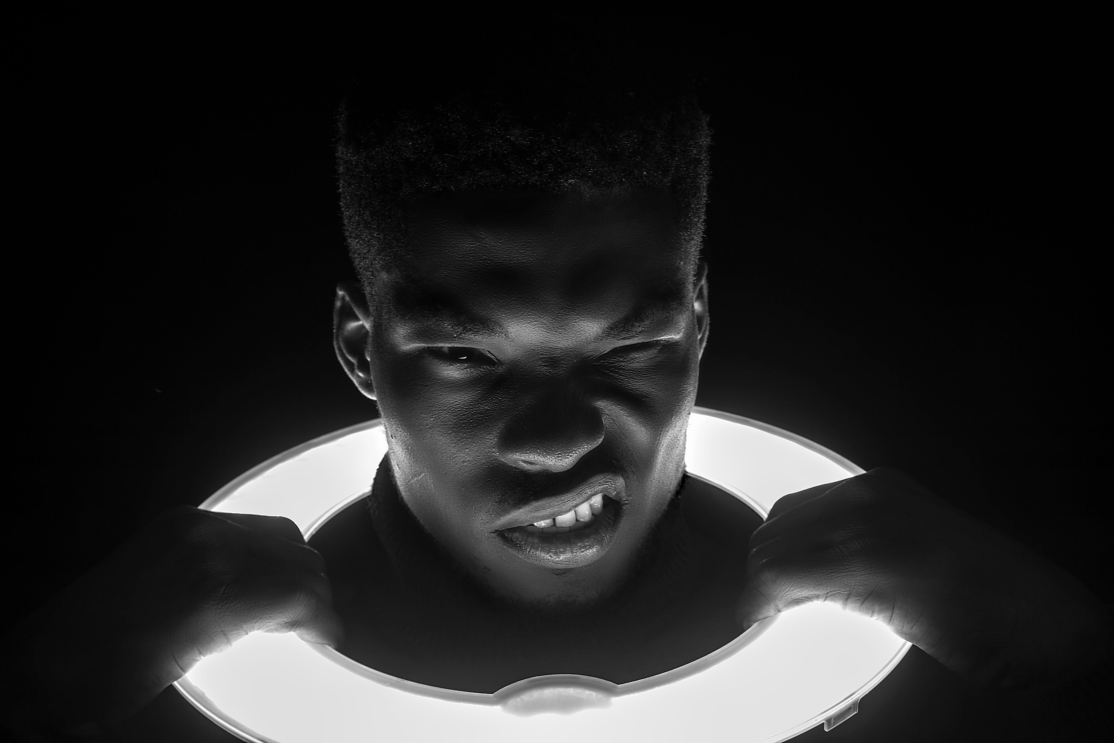 Black and White Photo of a Man with Light on Neck · Free Stock Photo