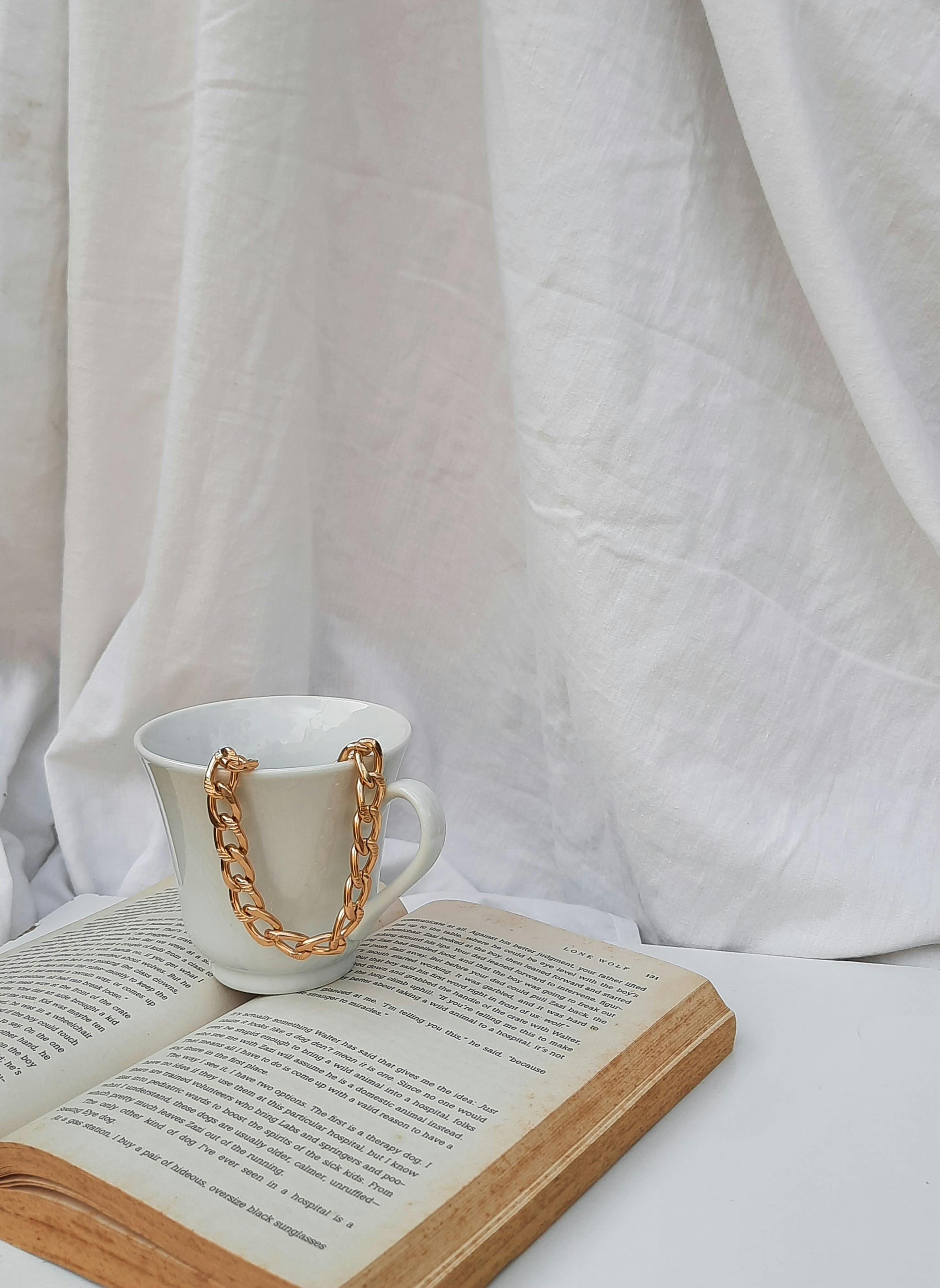Photo of a Gold Chain Necklace in a White Ceramic Mug · Free Stock Photo