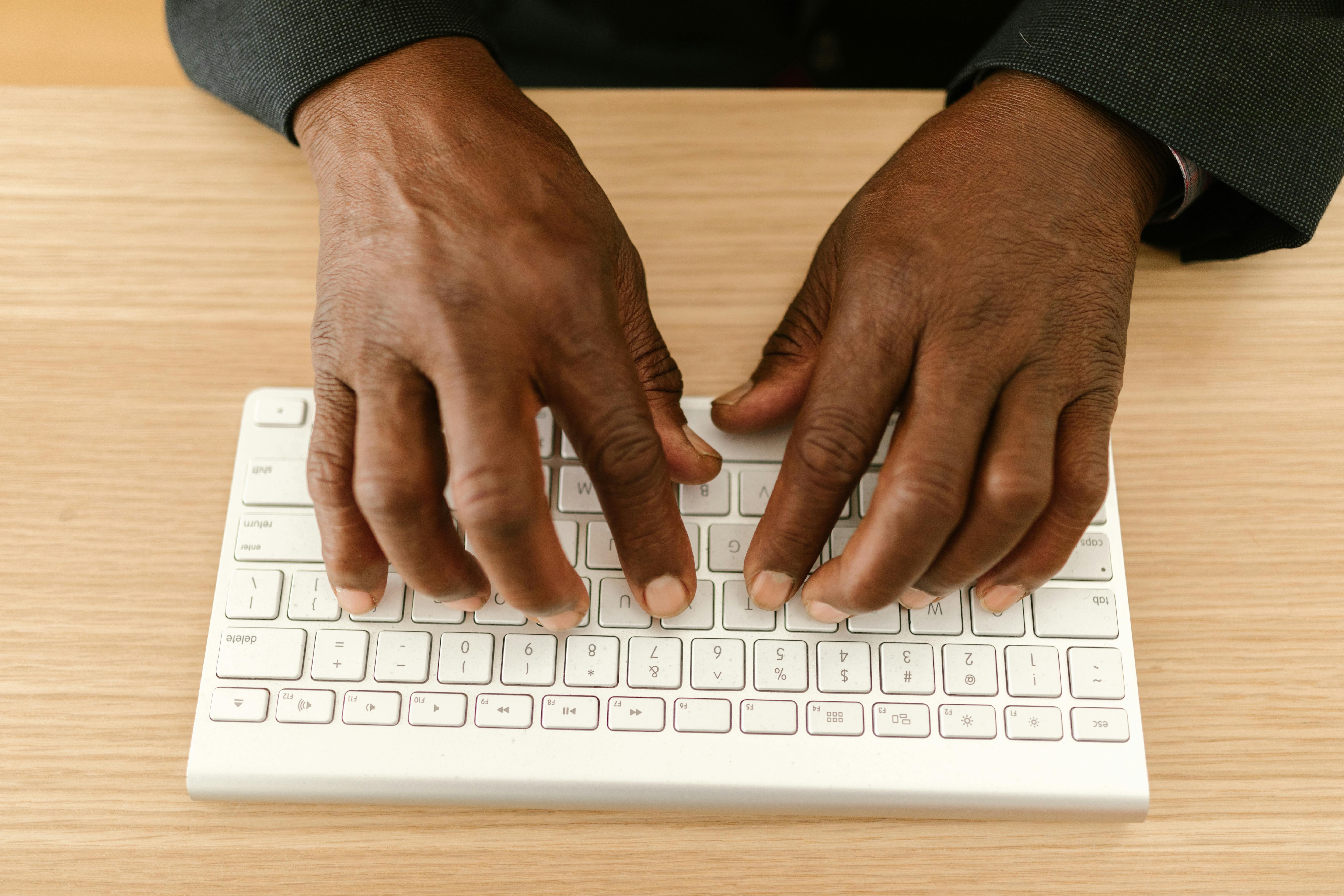 Person Typing on White Keyboard · Free Stock Photo