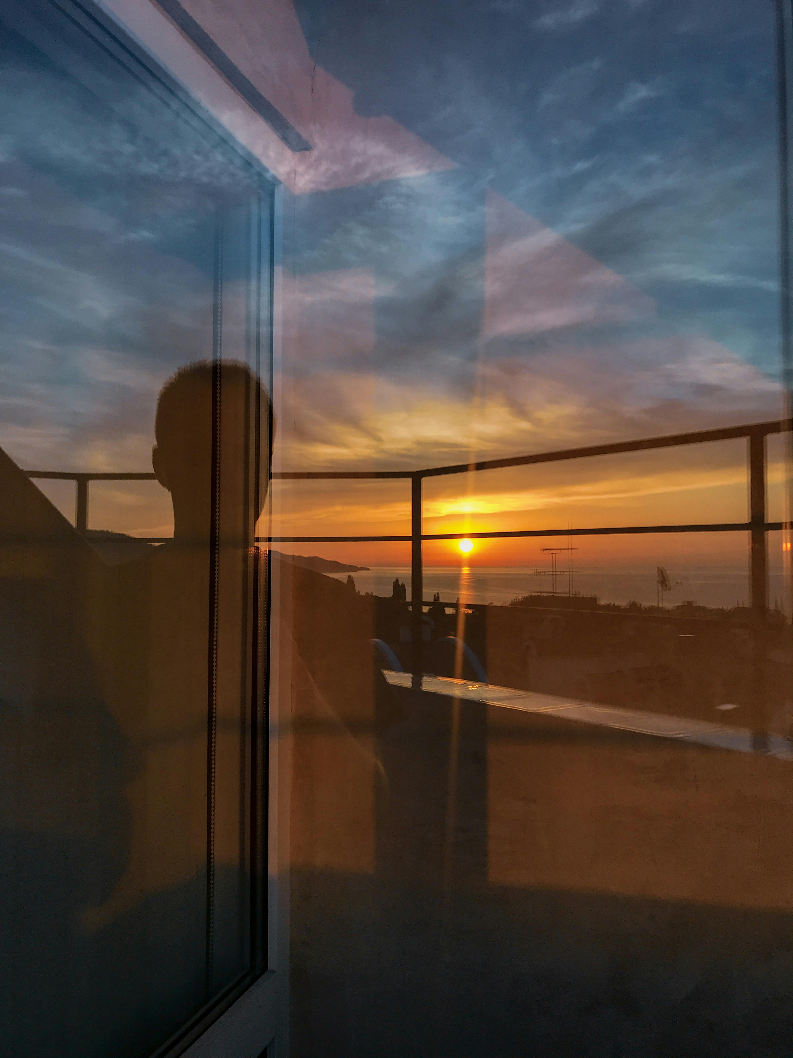 Reflection and Silhouette in Window at Sunset · Free Stock Photo