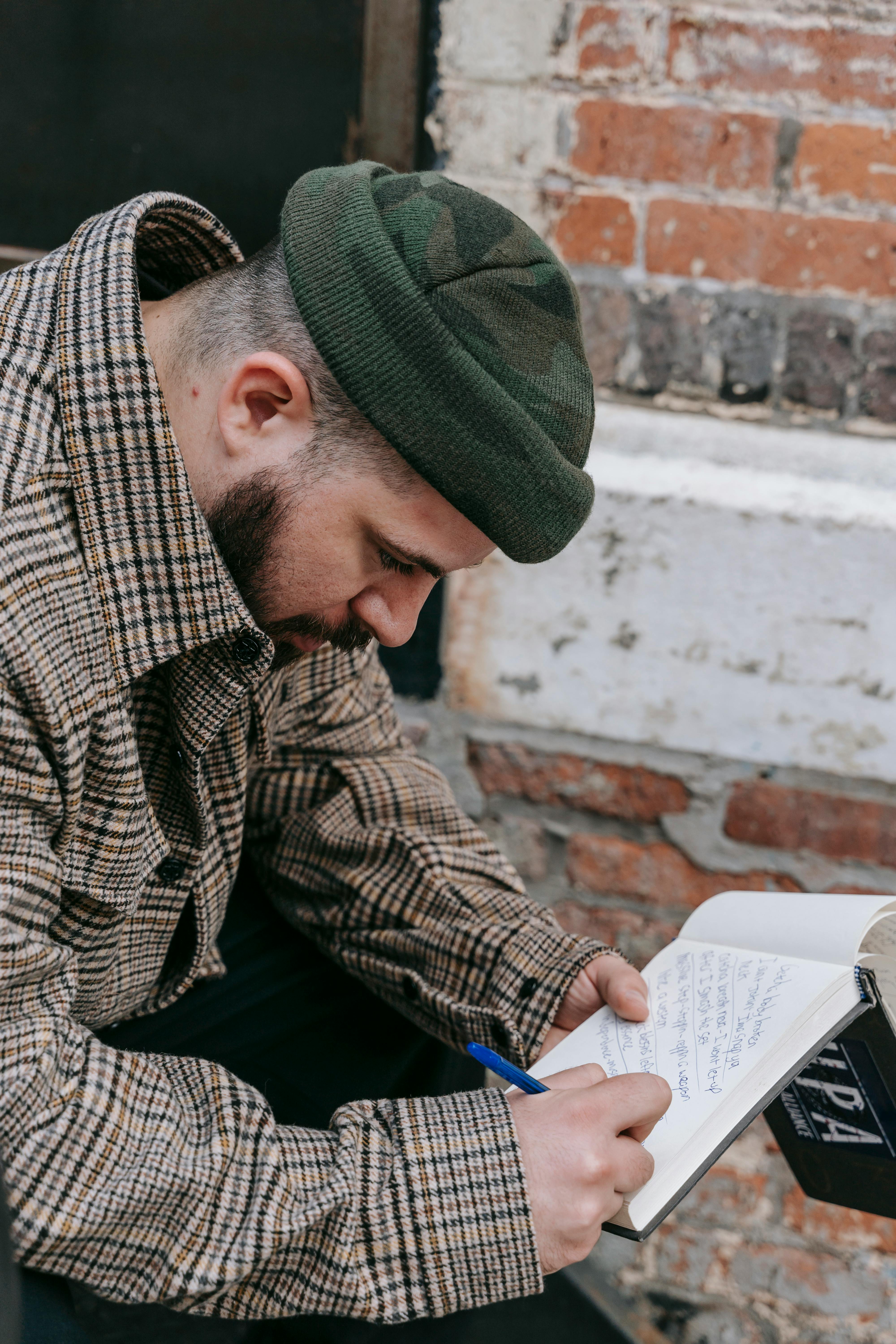 Bearded Man Writing on a N · Free Stock Photo