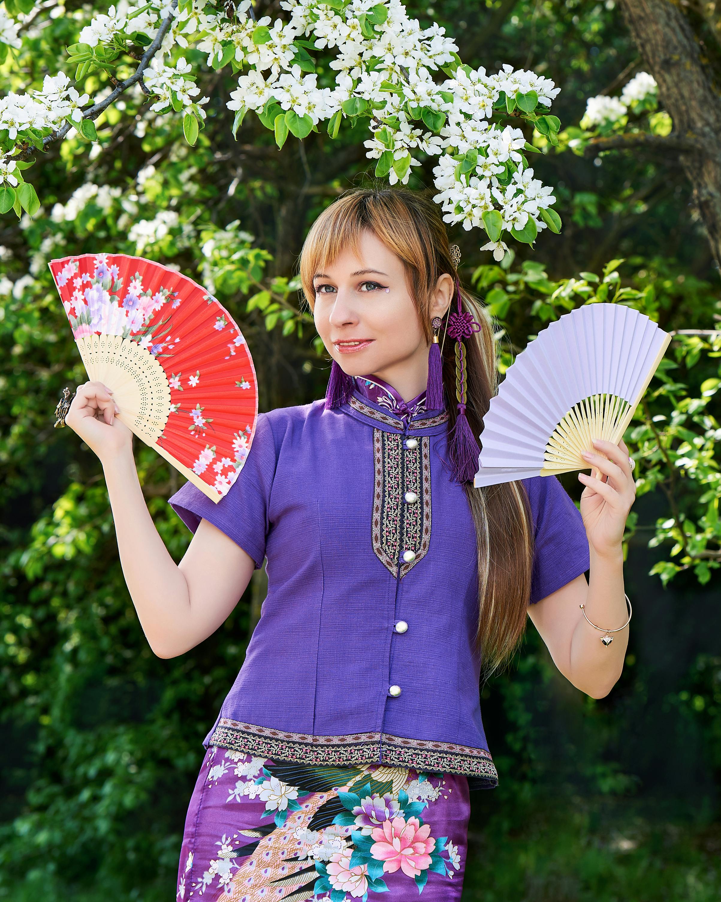 A Woman Sitting While Holding Hand Fan · Free Stock Photo