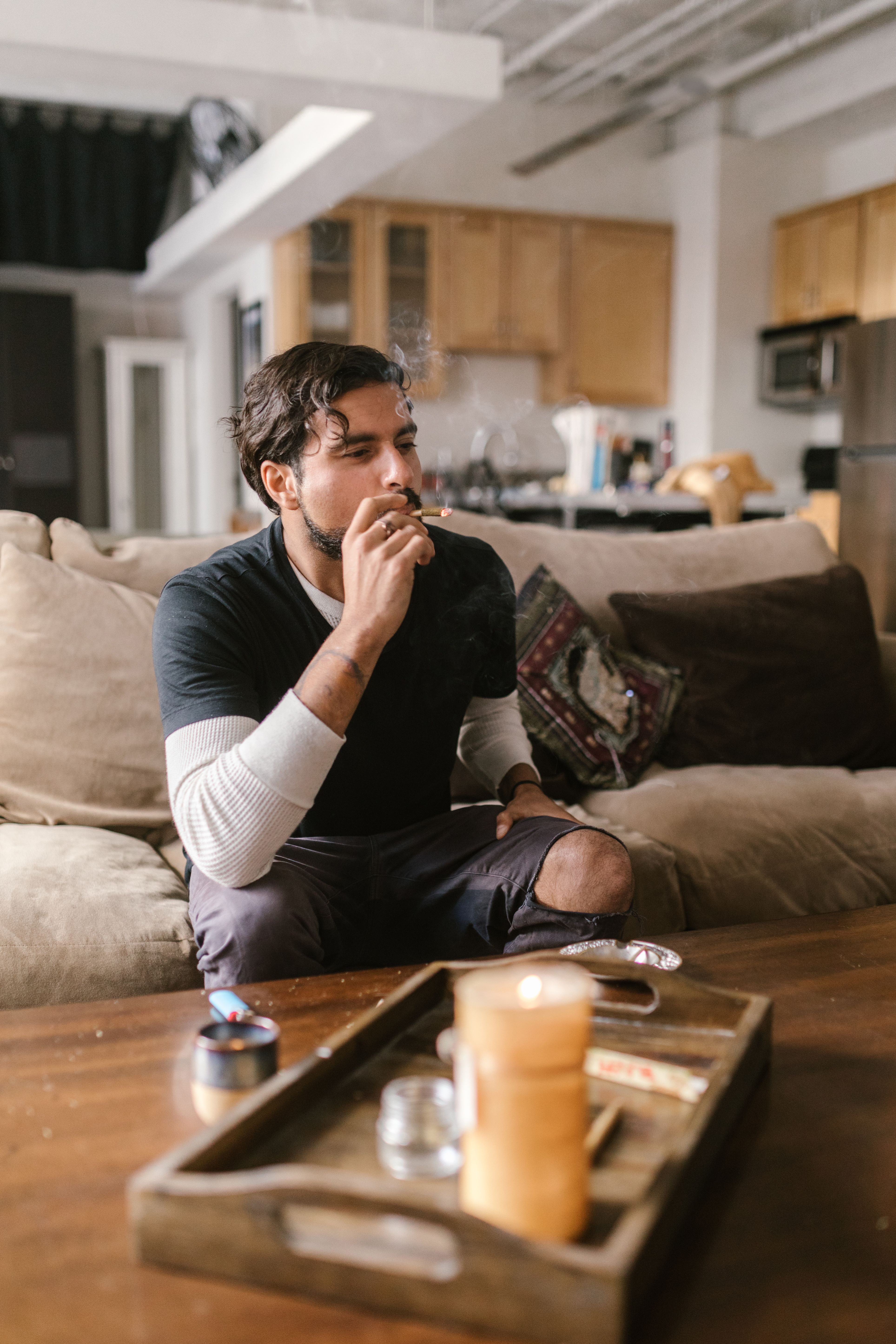 Man Sitting on Brown Couch and Smoking · Free Stock Photo