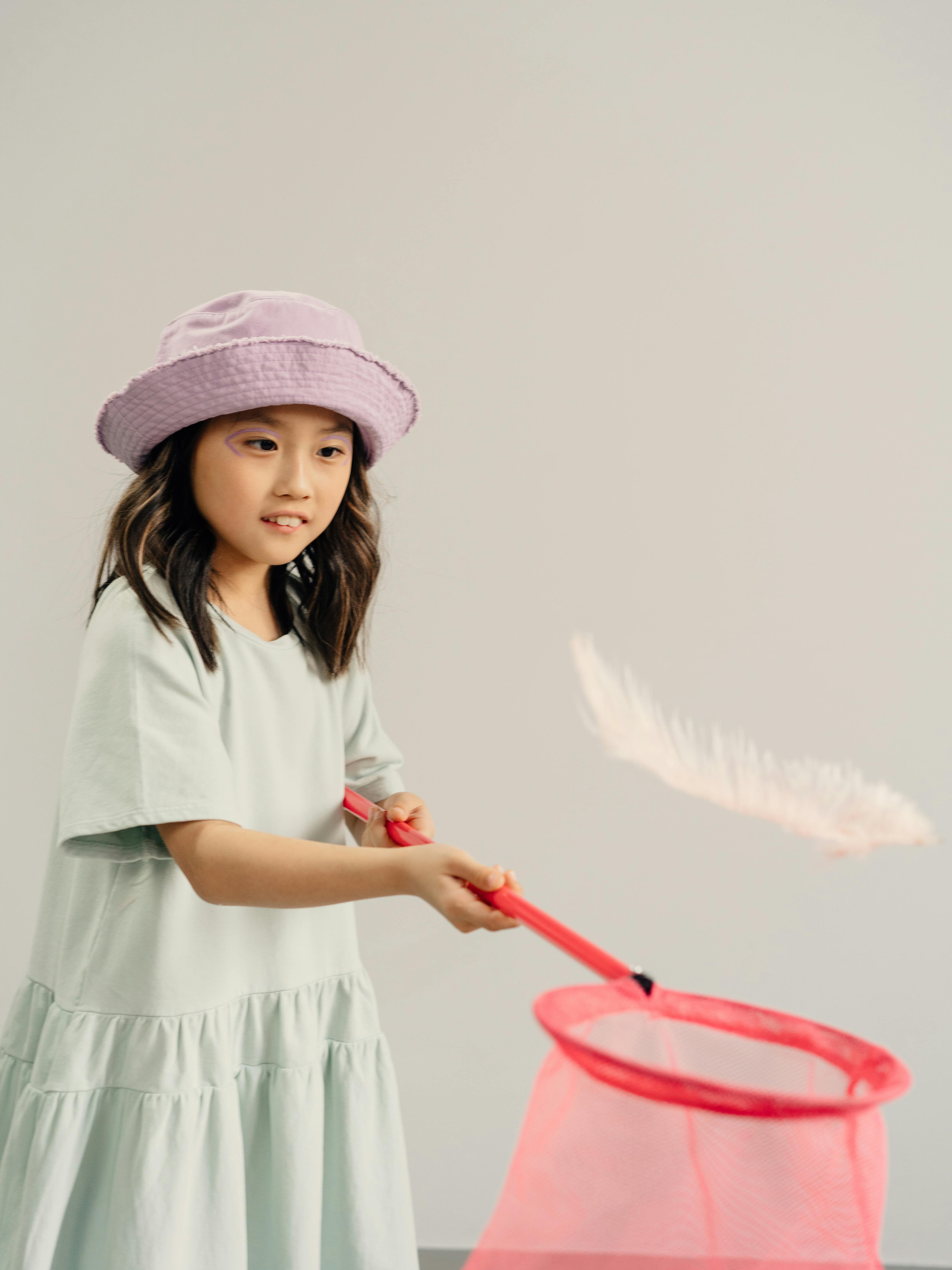 A Little Girl Trying to Catch a Feather with a Butterfly Net · Free ...