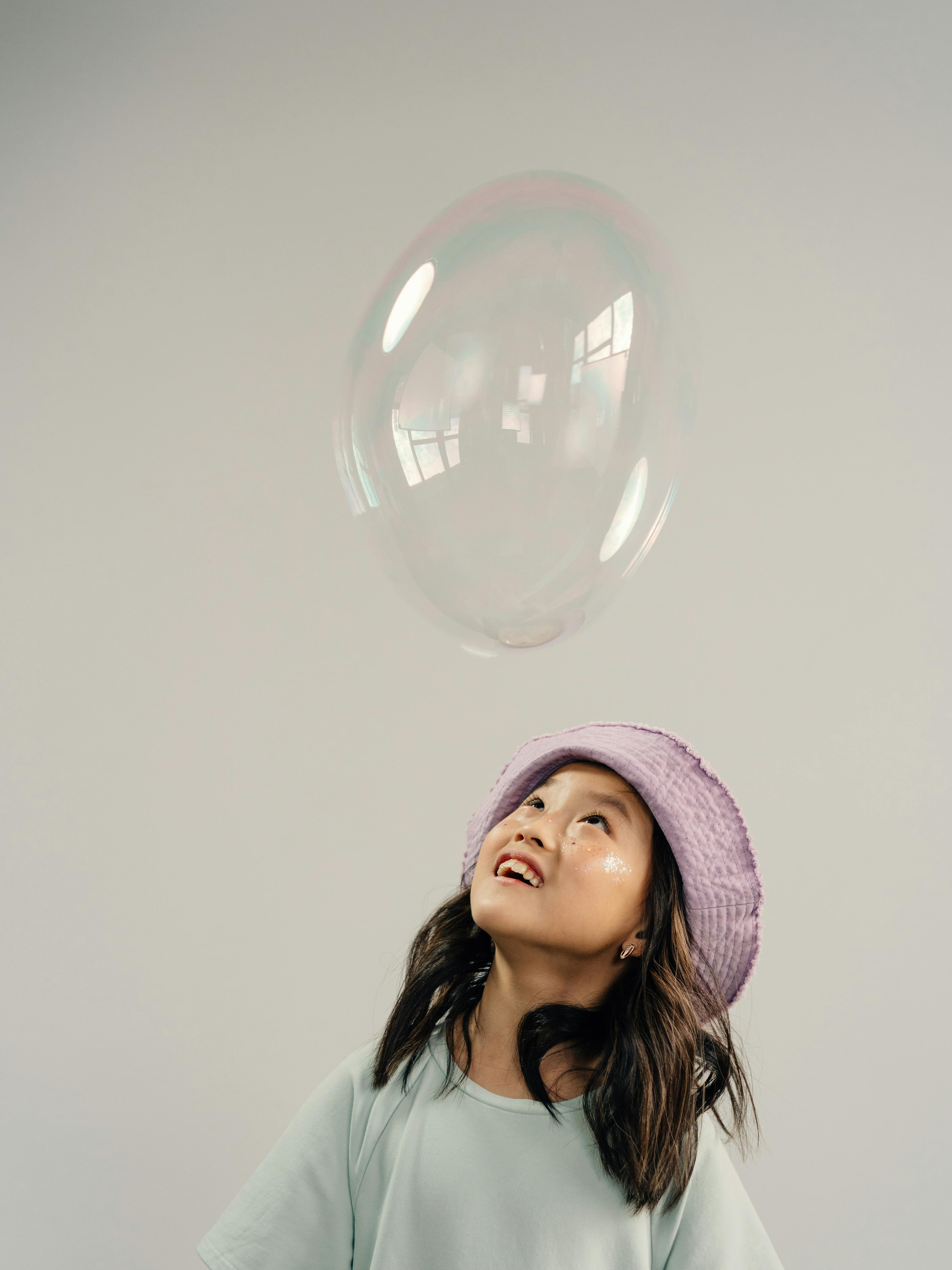 A Girl Wearing Bucket Hat Playing with Bubbles · Free Stock Photo