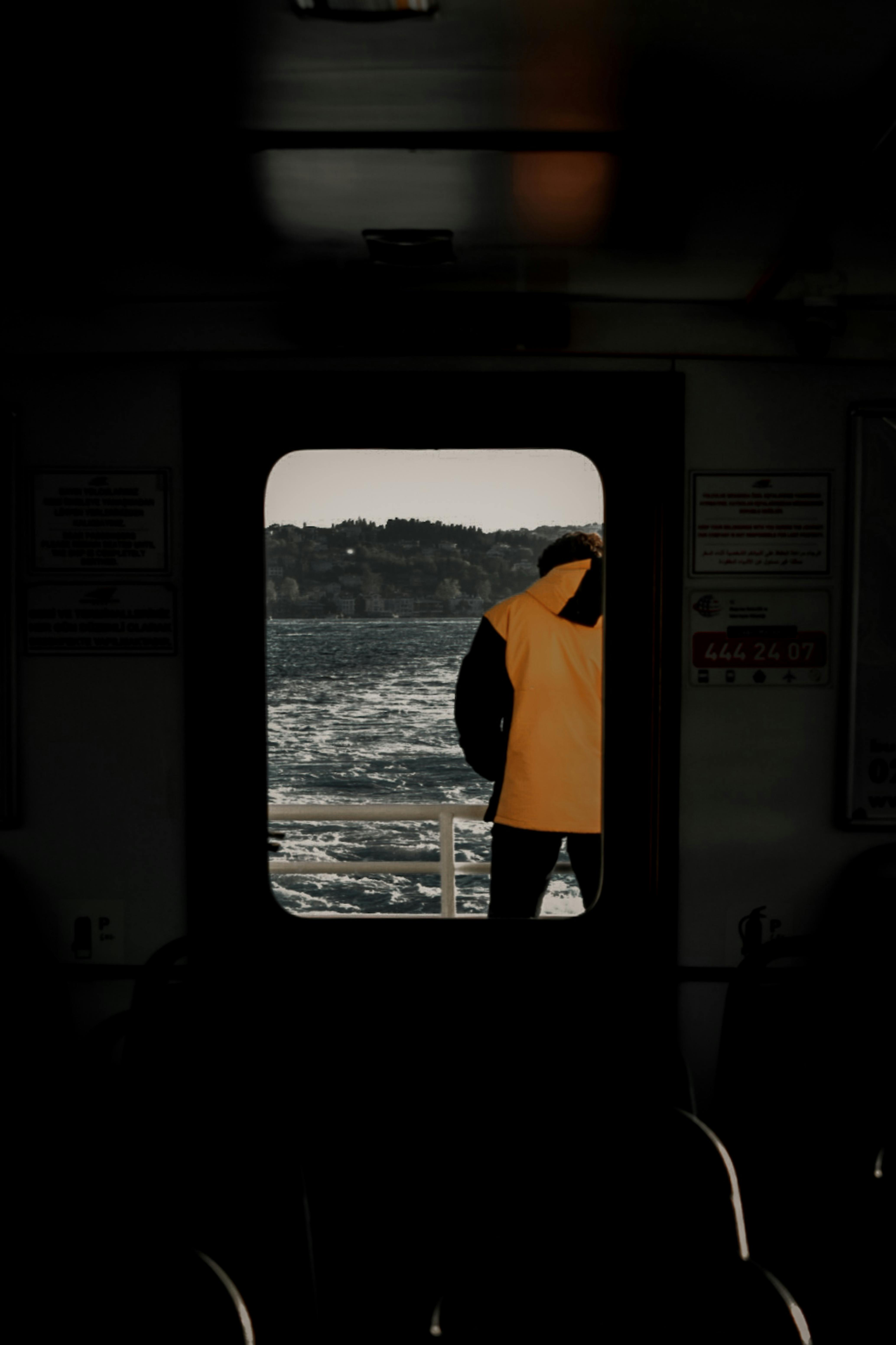 A Man Standing Beside the Glass Window · Free Stock Photo