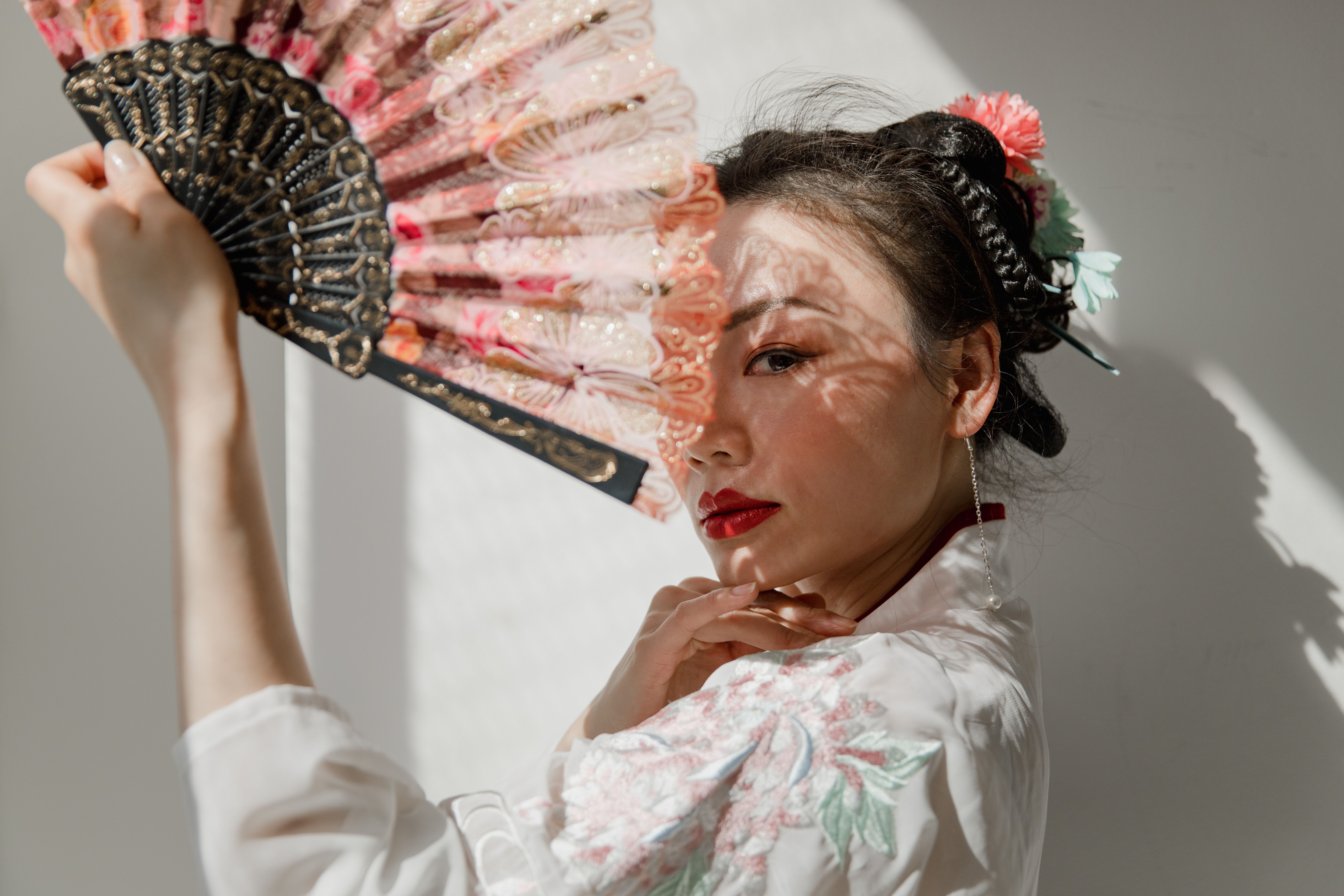 A Woman Covering Her Face with a Fan · Free Stock Photo