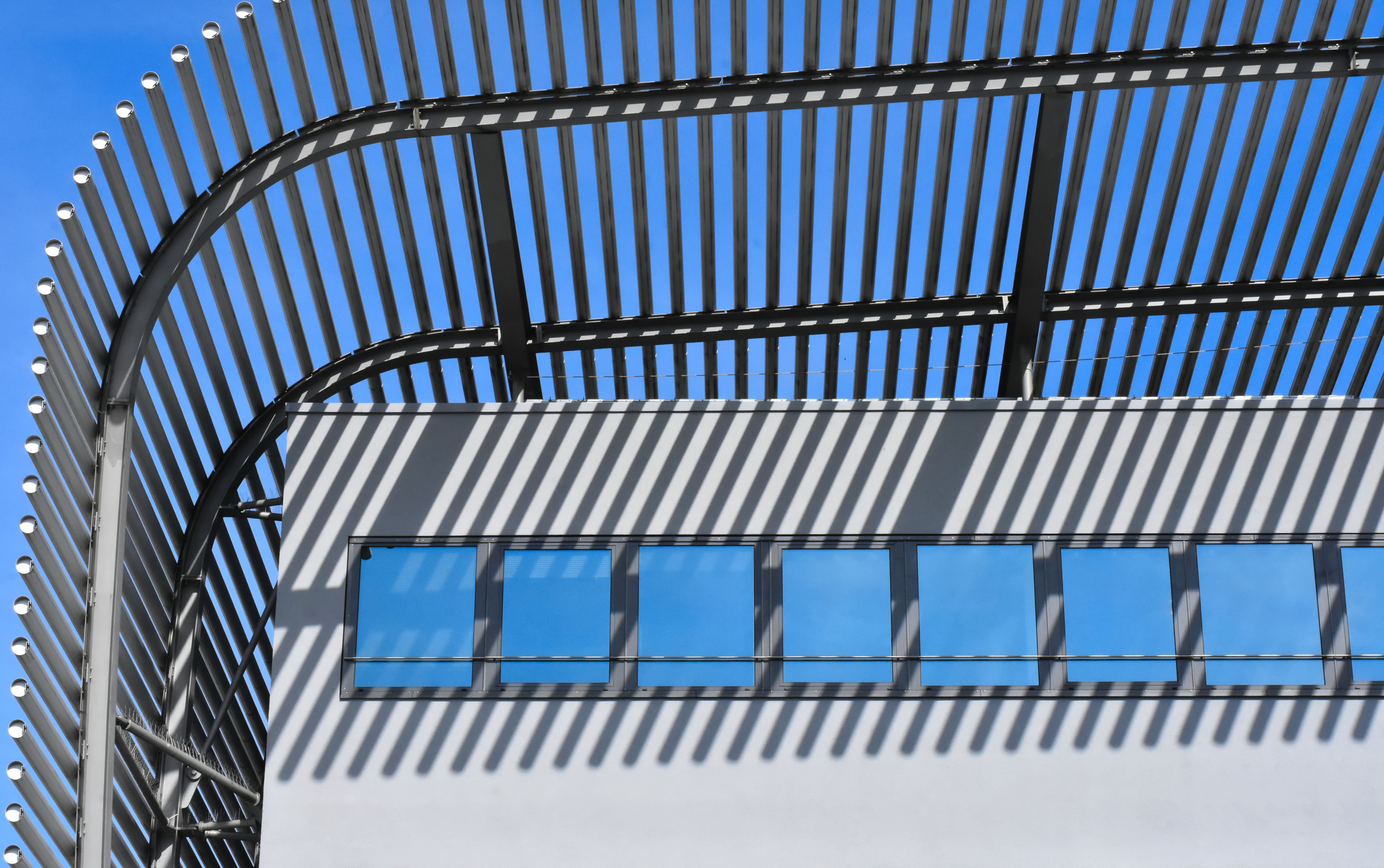 Metal Grating Stretching Over a Row of Windows · Free Stock Photo