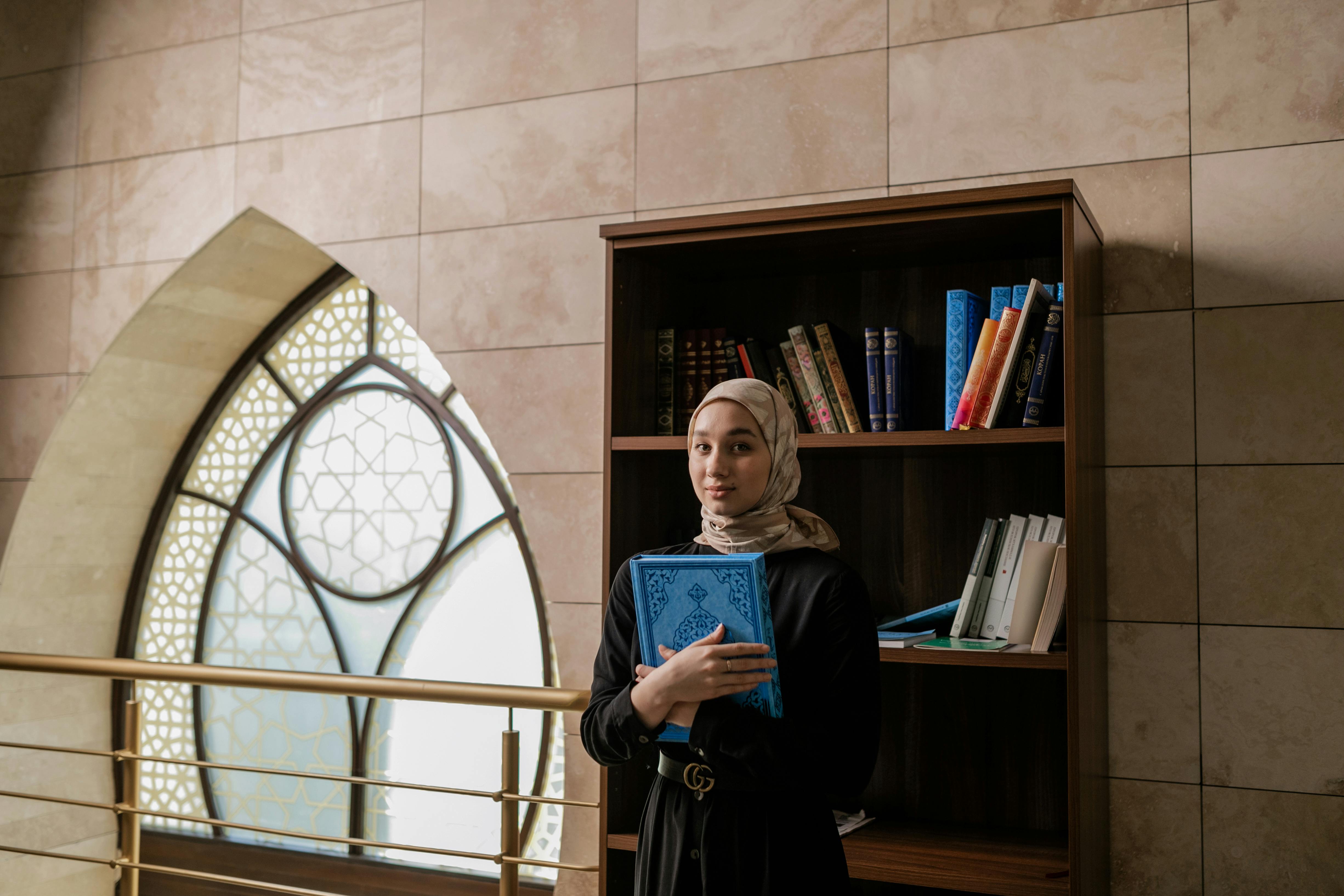 Woman in Black Dress Holding Blue Book Standing Near Brown Wooden Book ...