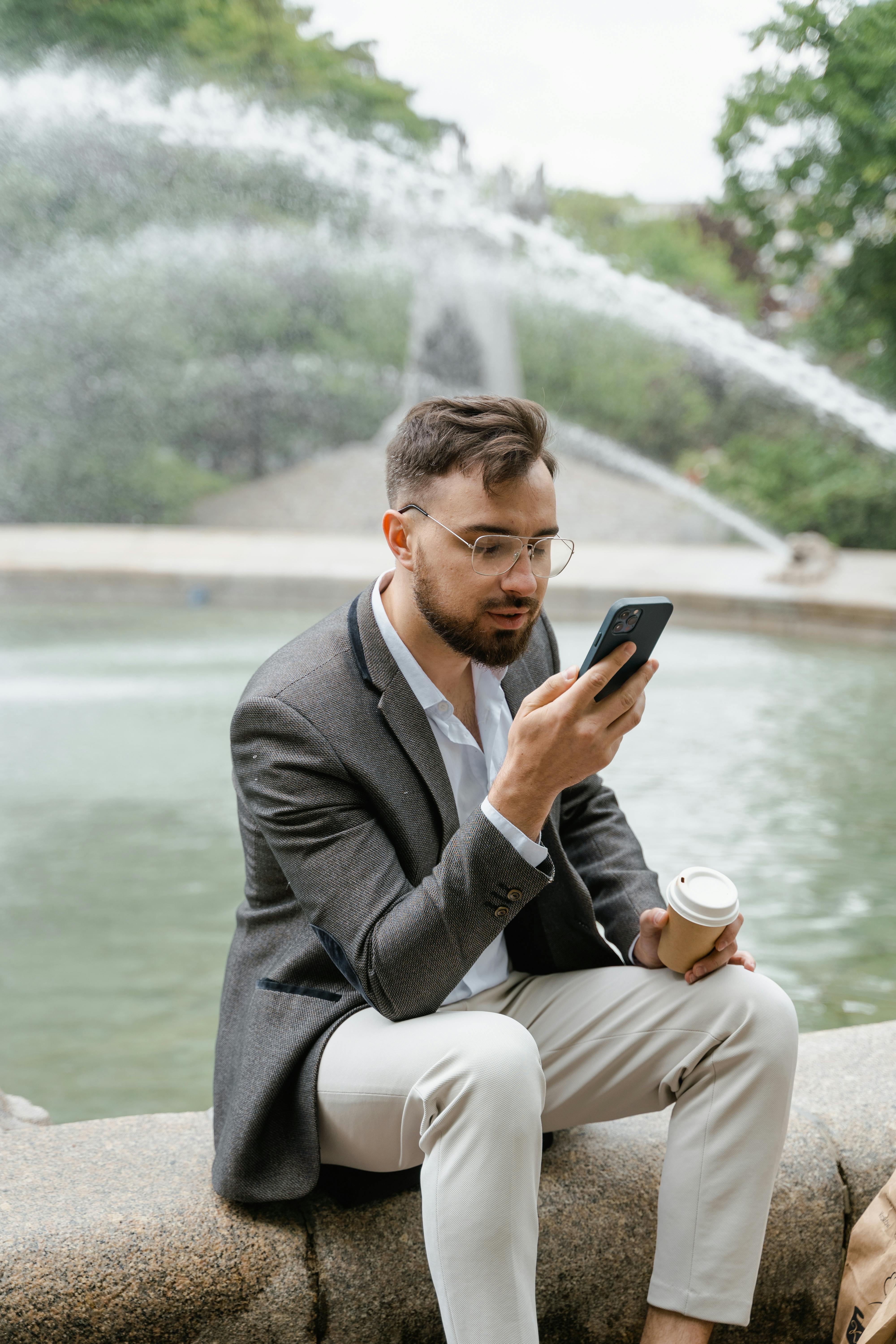 Man in Gray Blazer Texting on a Smartphone · Free Stock Photo