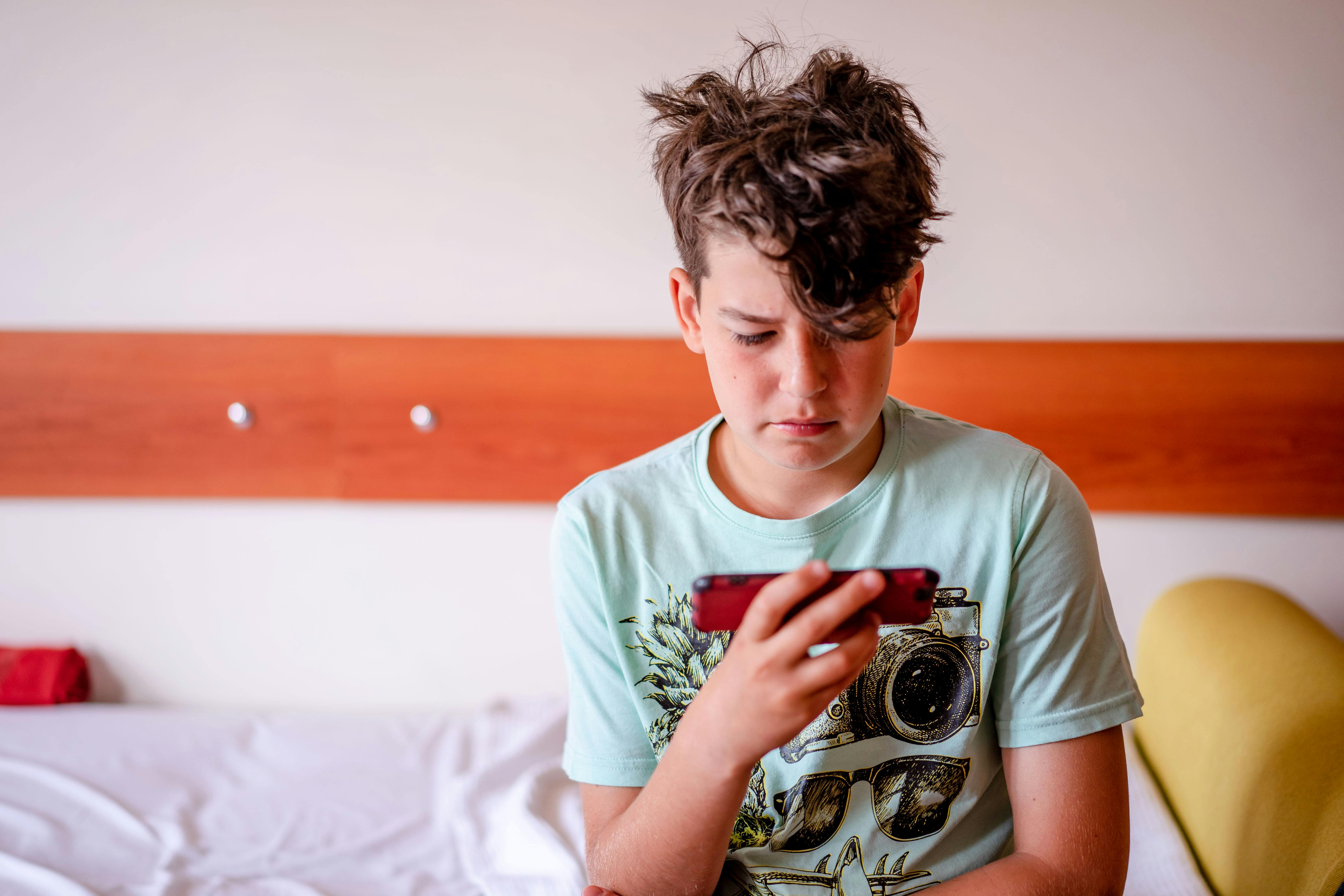 A Boy Playing on the Smartphone · Free Stock Photo