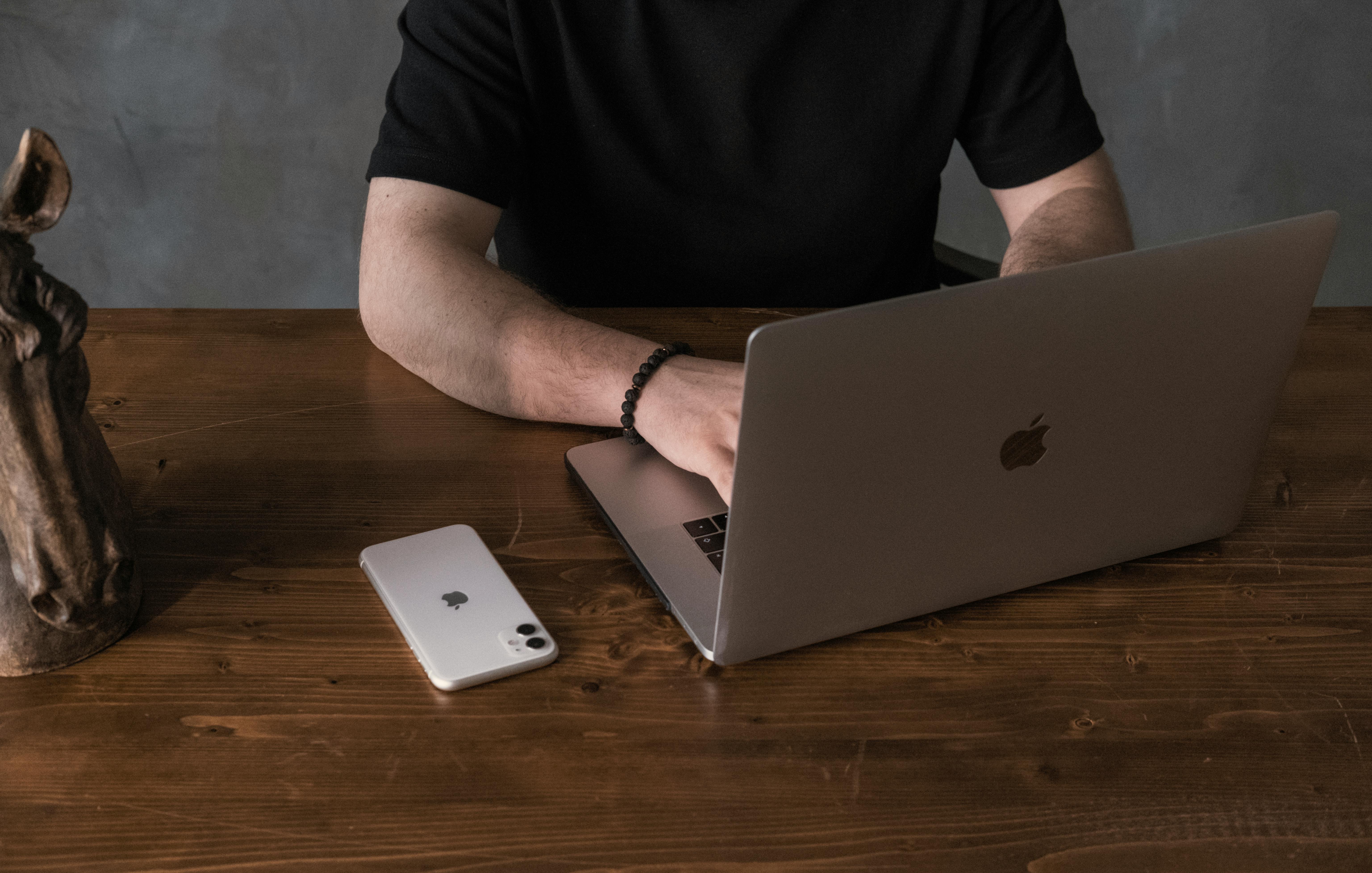 Crop man using laptop at table · Free Stock Photo
