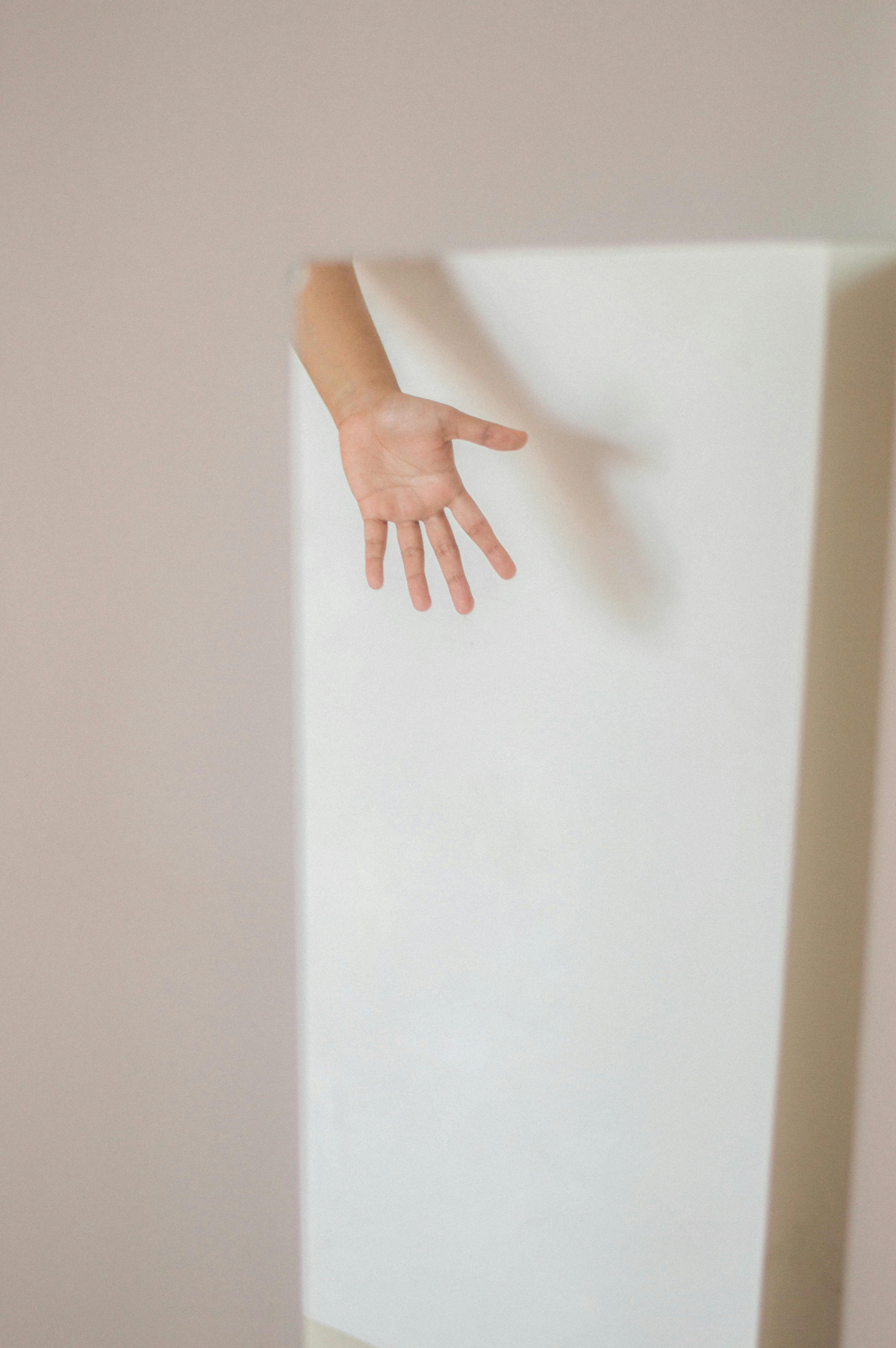 Right Human Hand Beside White Painted Wall · Free Stock Photo