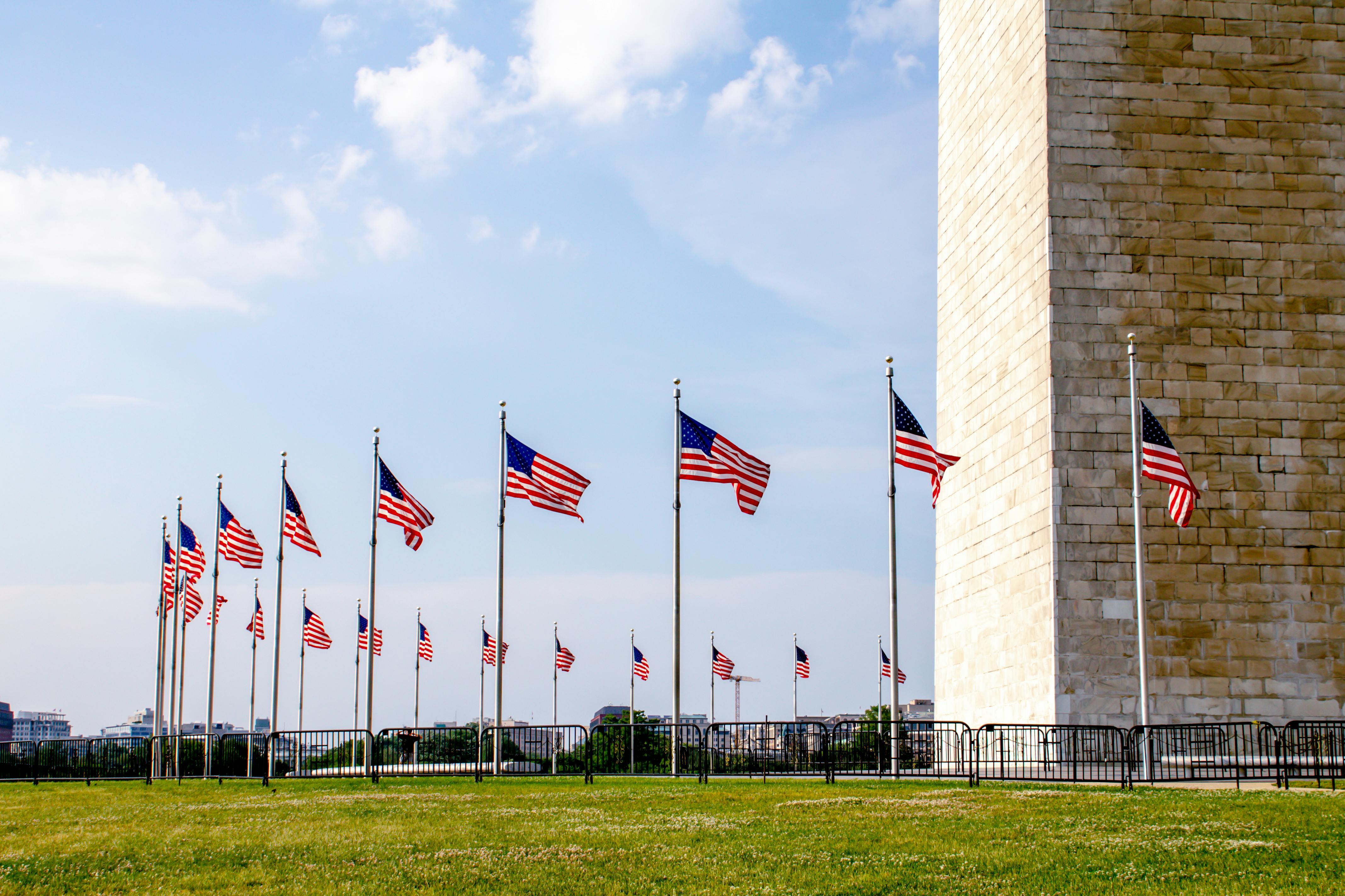 USA Flags Flying on Lawn in Front of Building · Free Stock Photo
