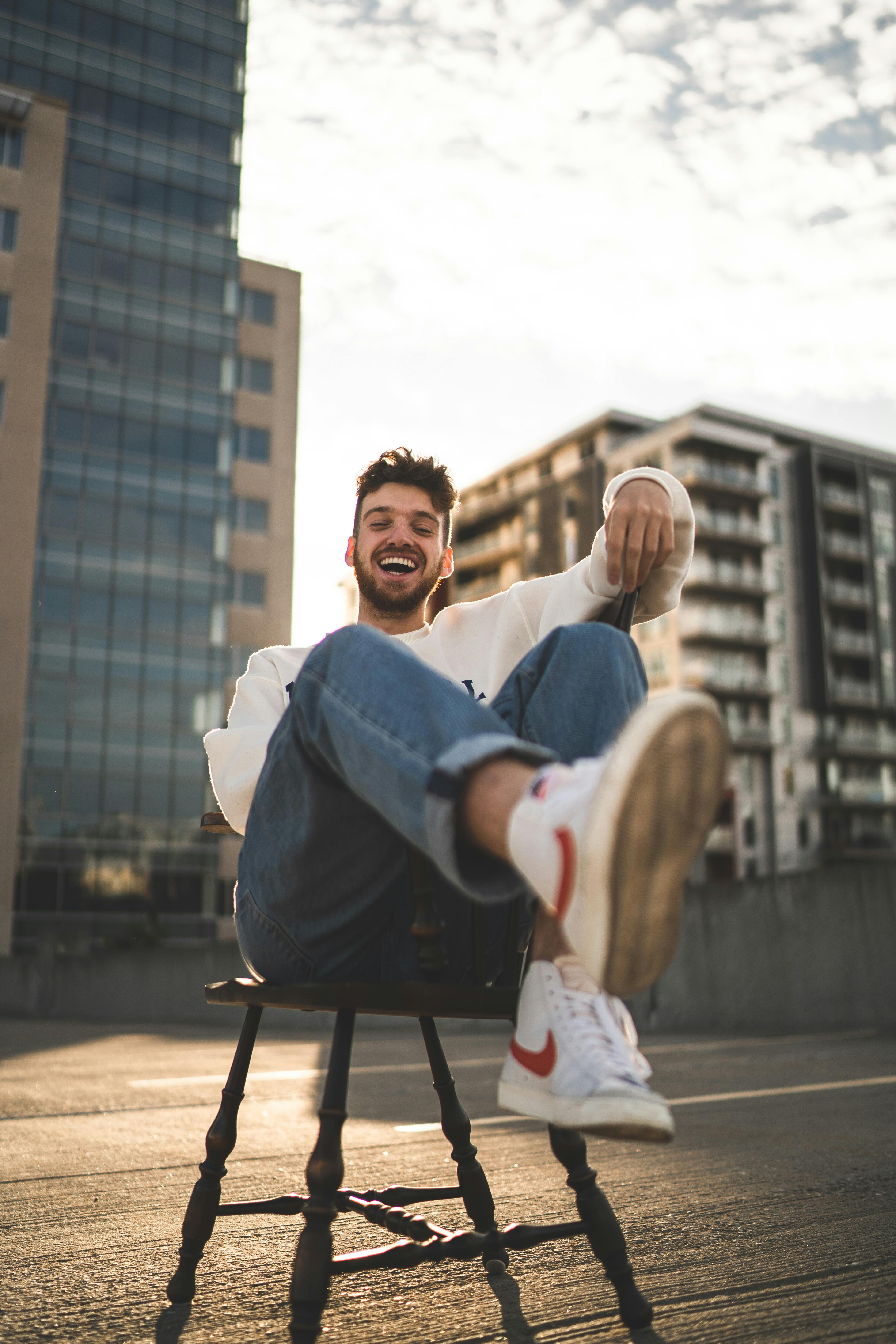 A Man Sitting on a Chair and Smiling · Free Stock Photo