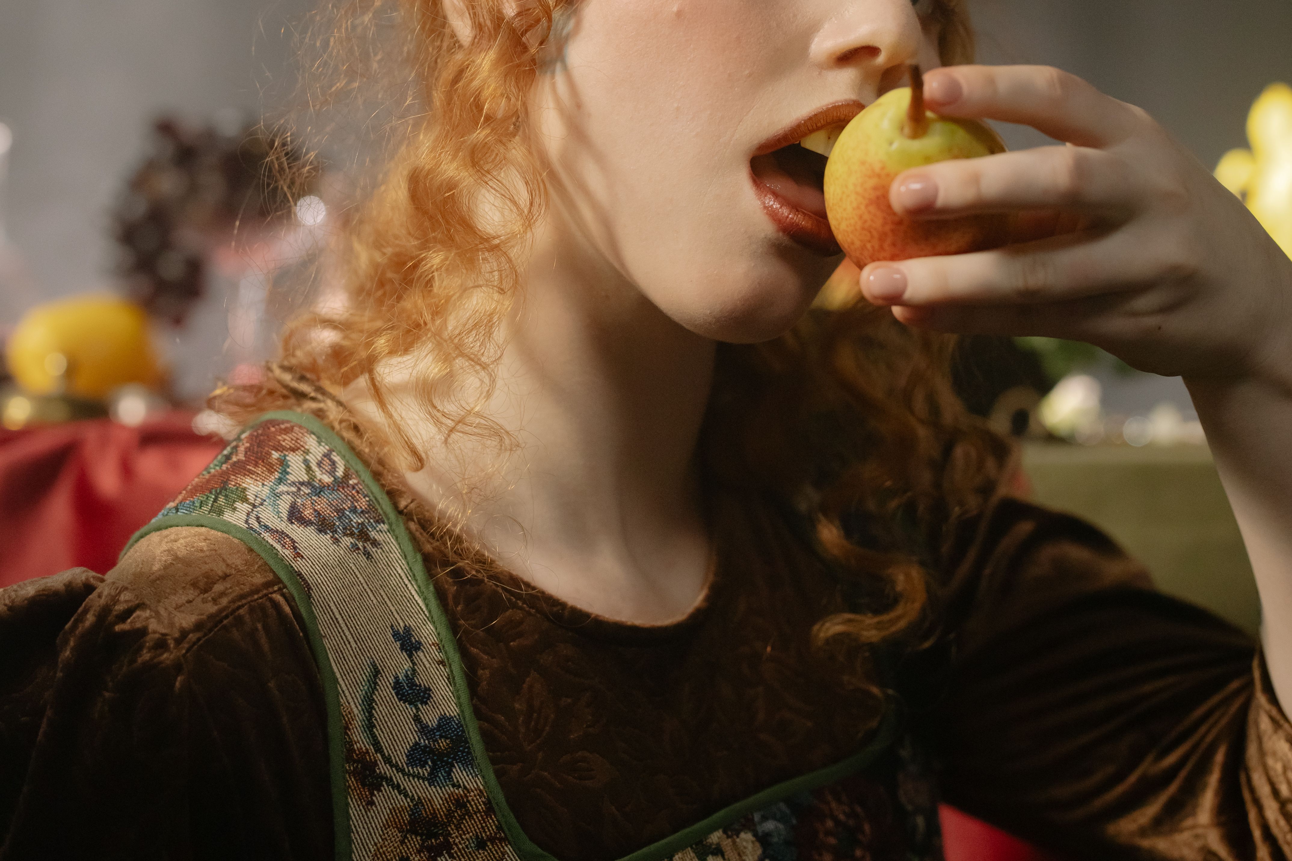 A Woman Eating a Fruit · Free Stock Photo