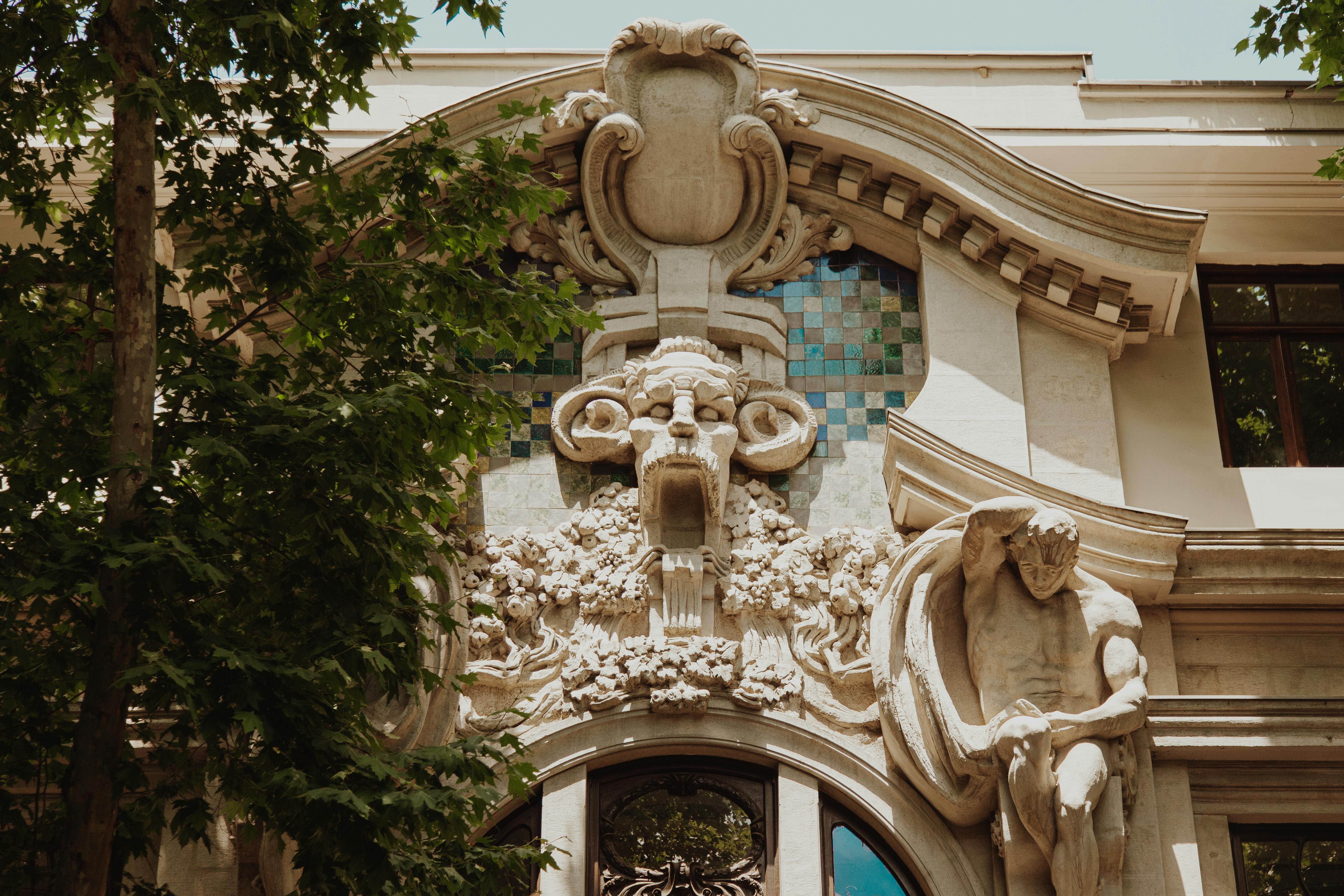 Sculpture on the Entrance of a White Building · Free Stock Photo